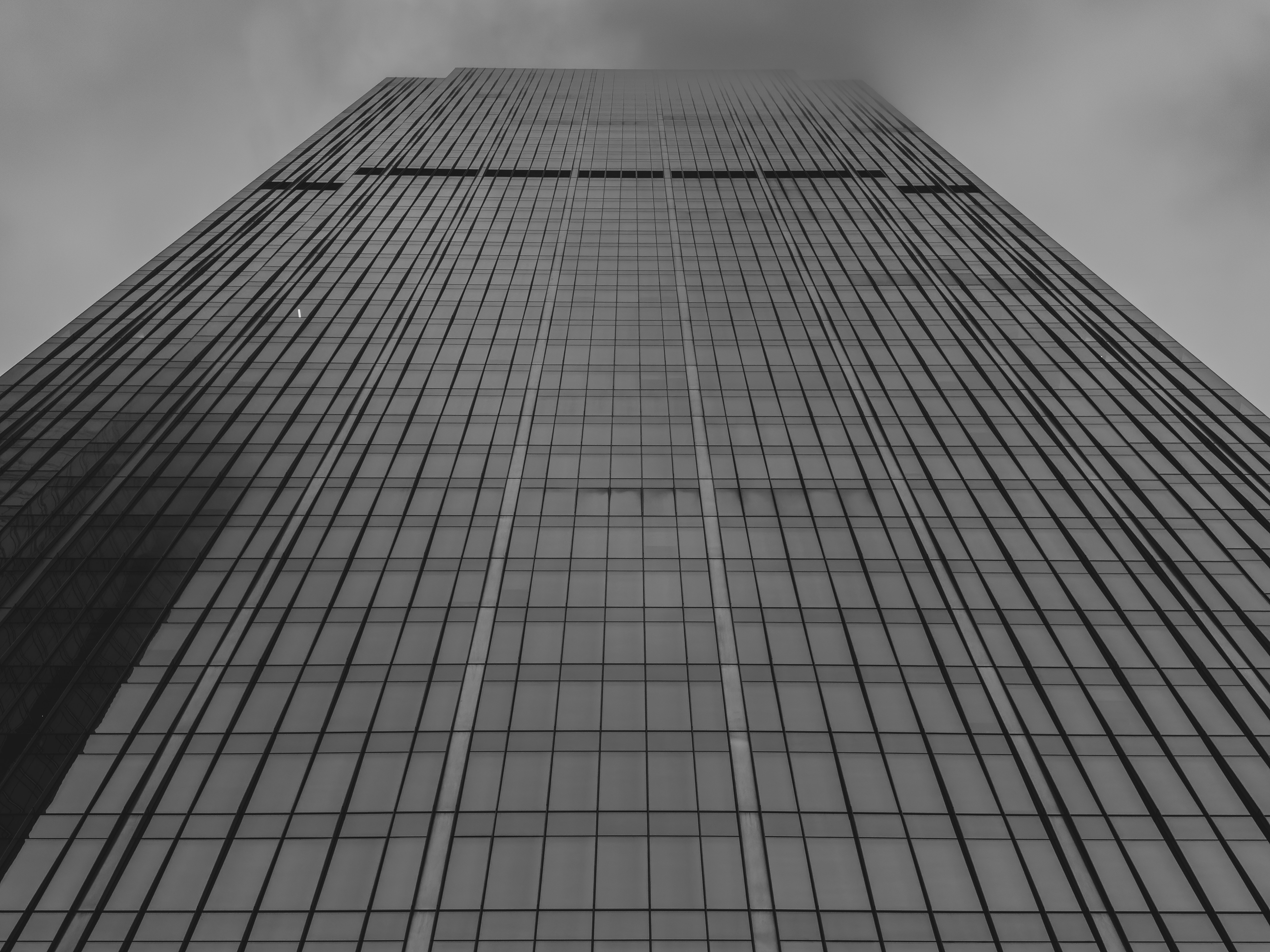Upward gaze: a glass-clad tower reaching toward the overcast sky