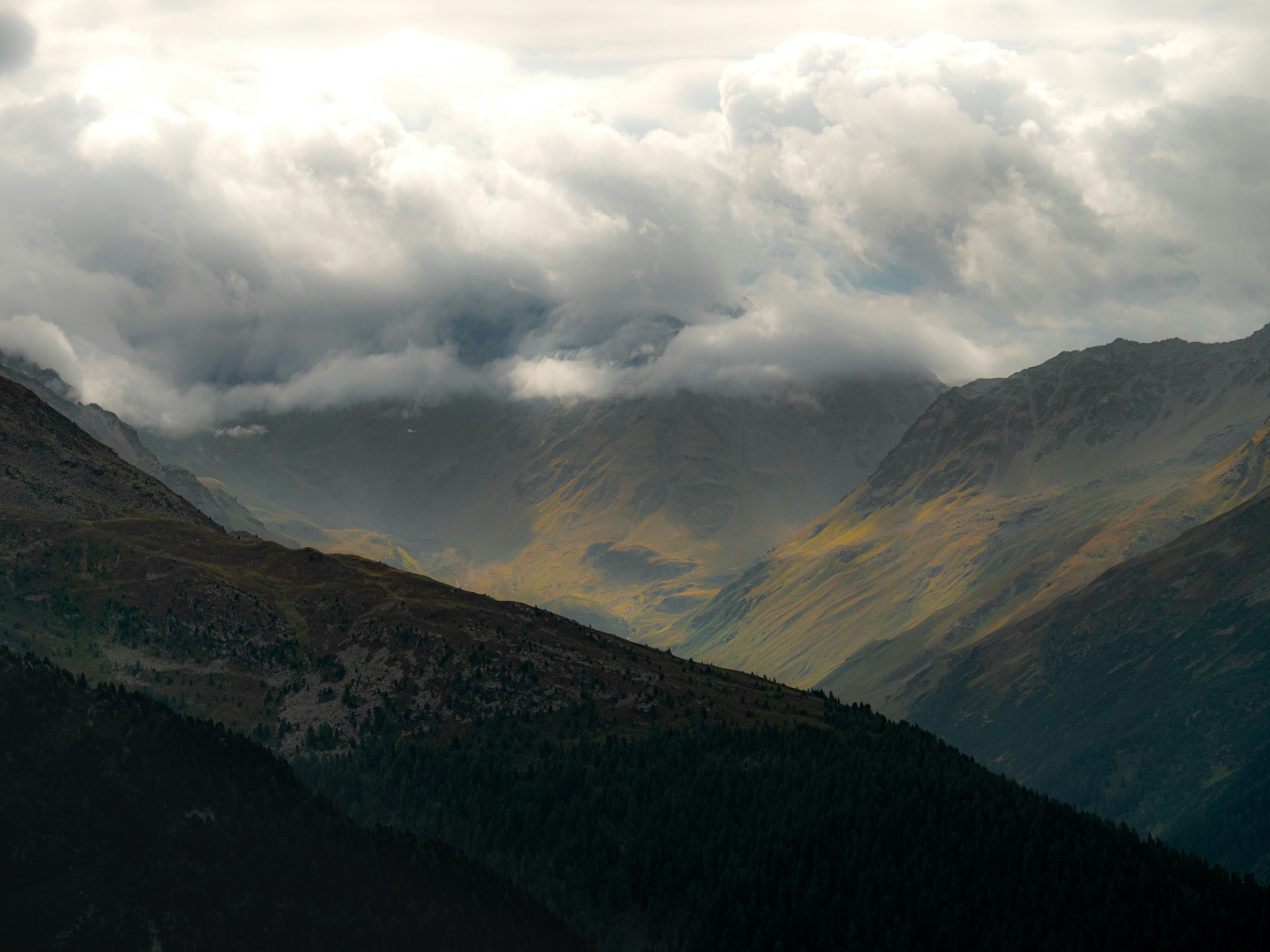 Cloud-Wedged Ridge: A Quiet Alpine Line Beyond the Foreground