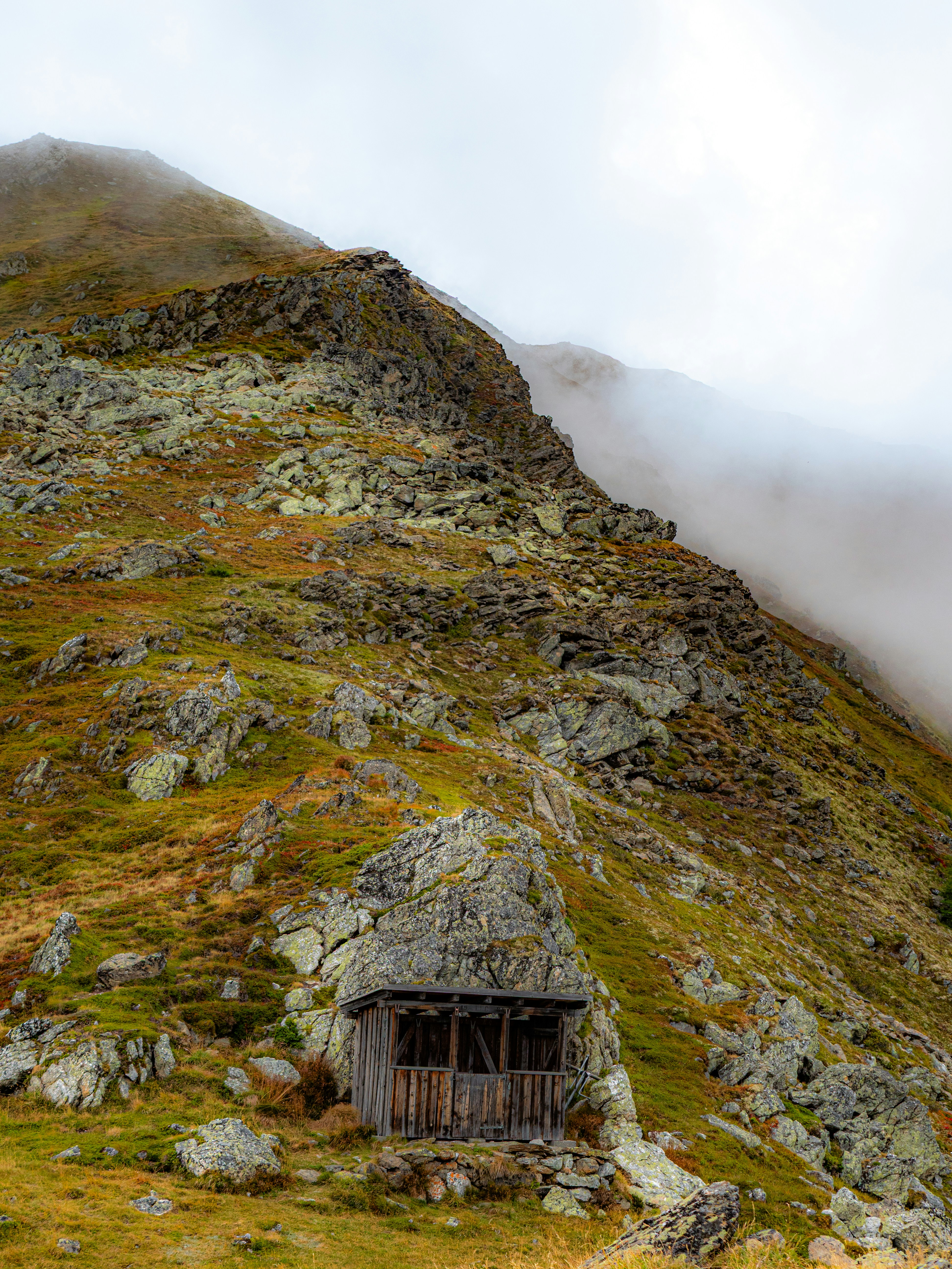 Mountain Shelter Amid Rugged Rocks and Mist