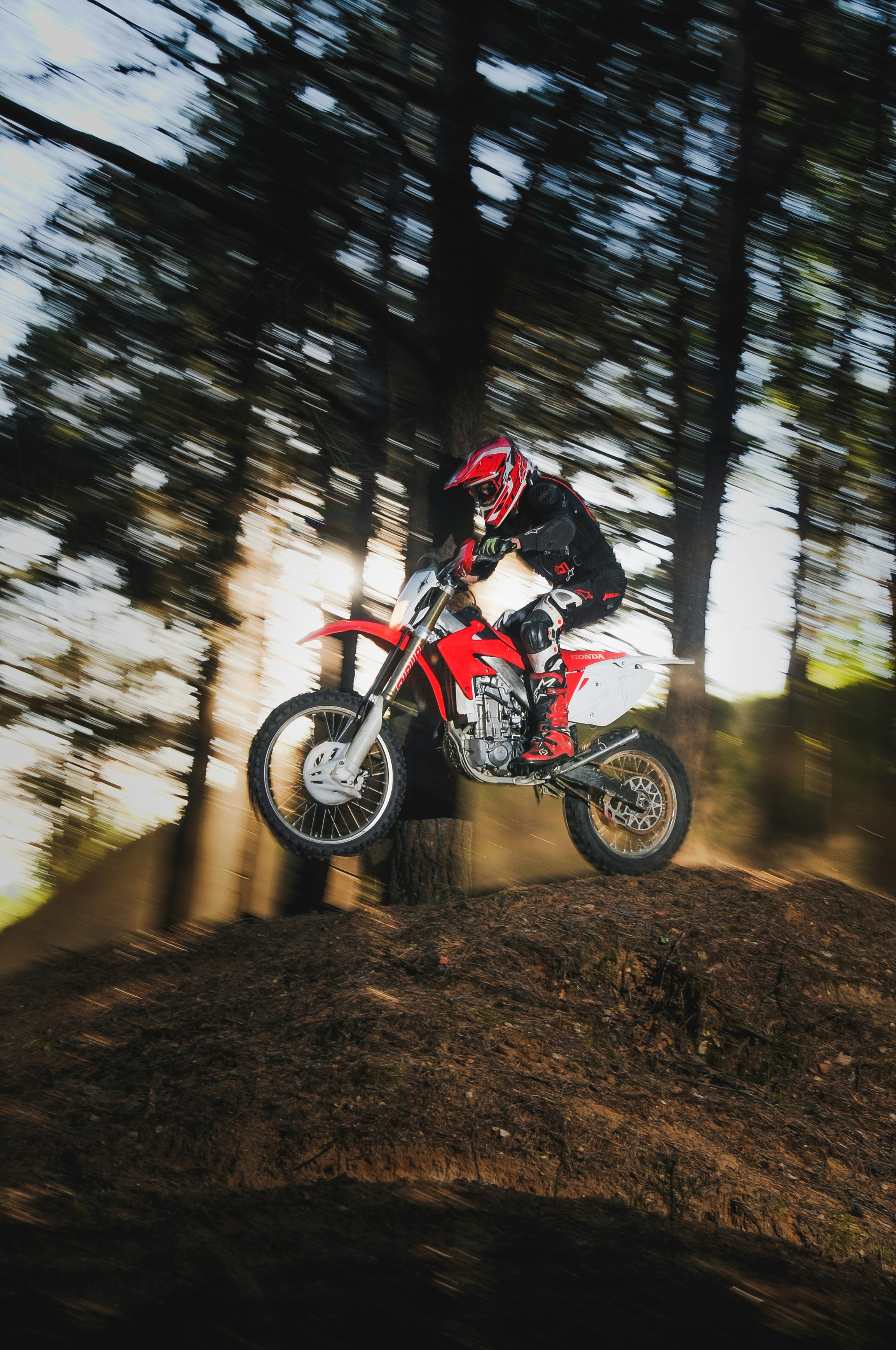 Freed in Flight: Red Moto Spearheading a Forest Jump