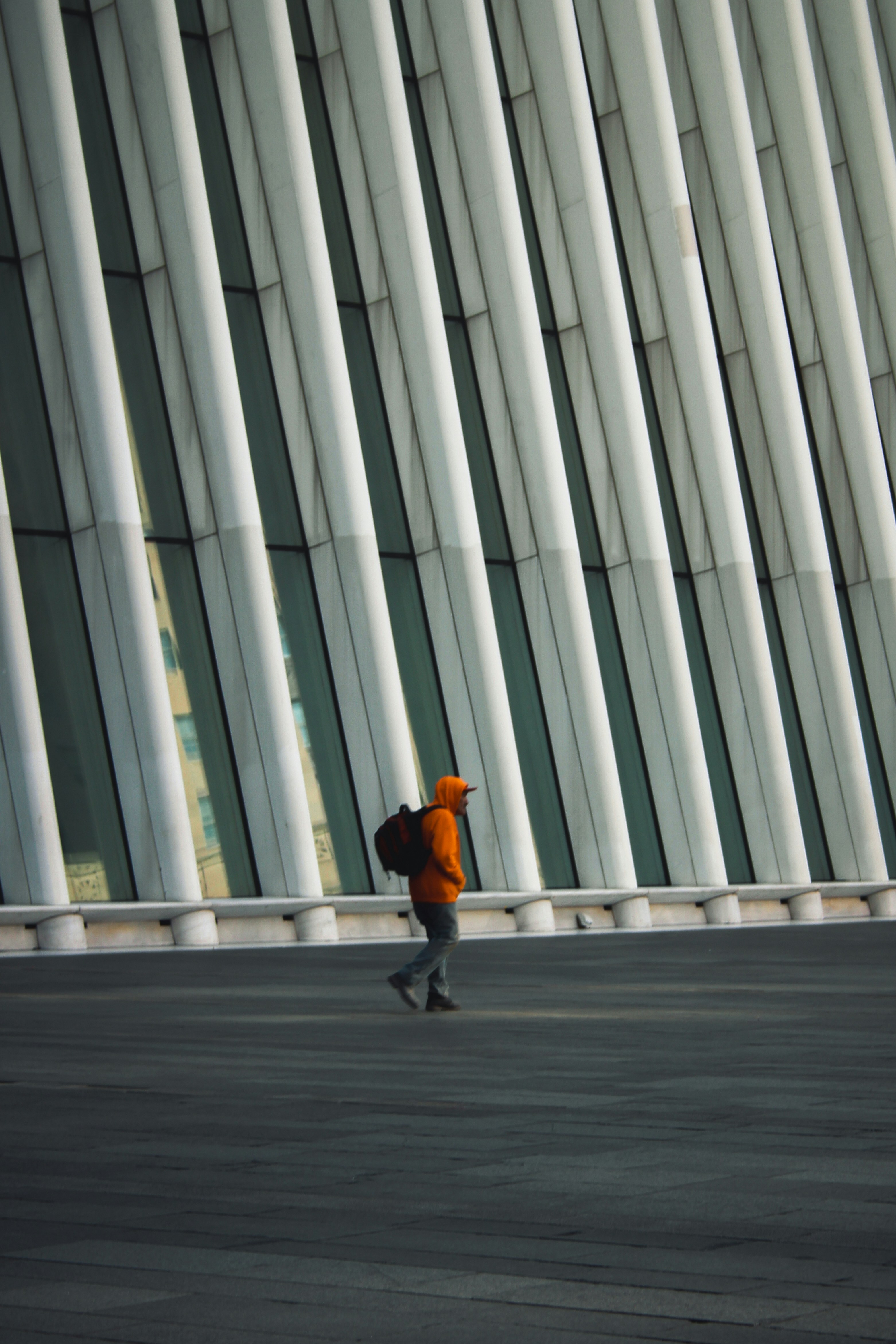 Orange Hoodie on a Quiet Journey Past Modern Facades