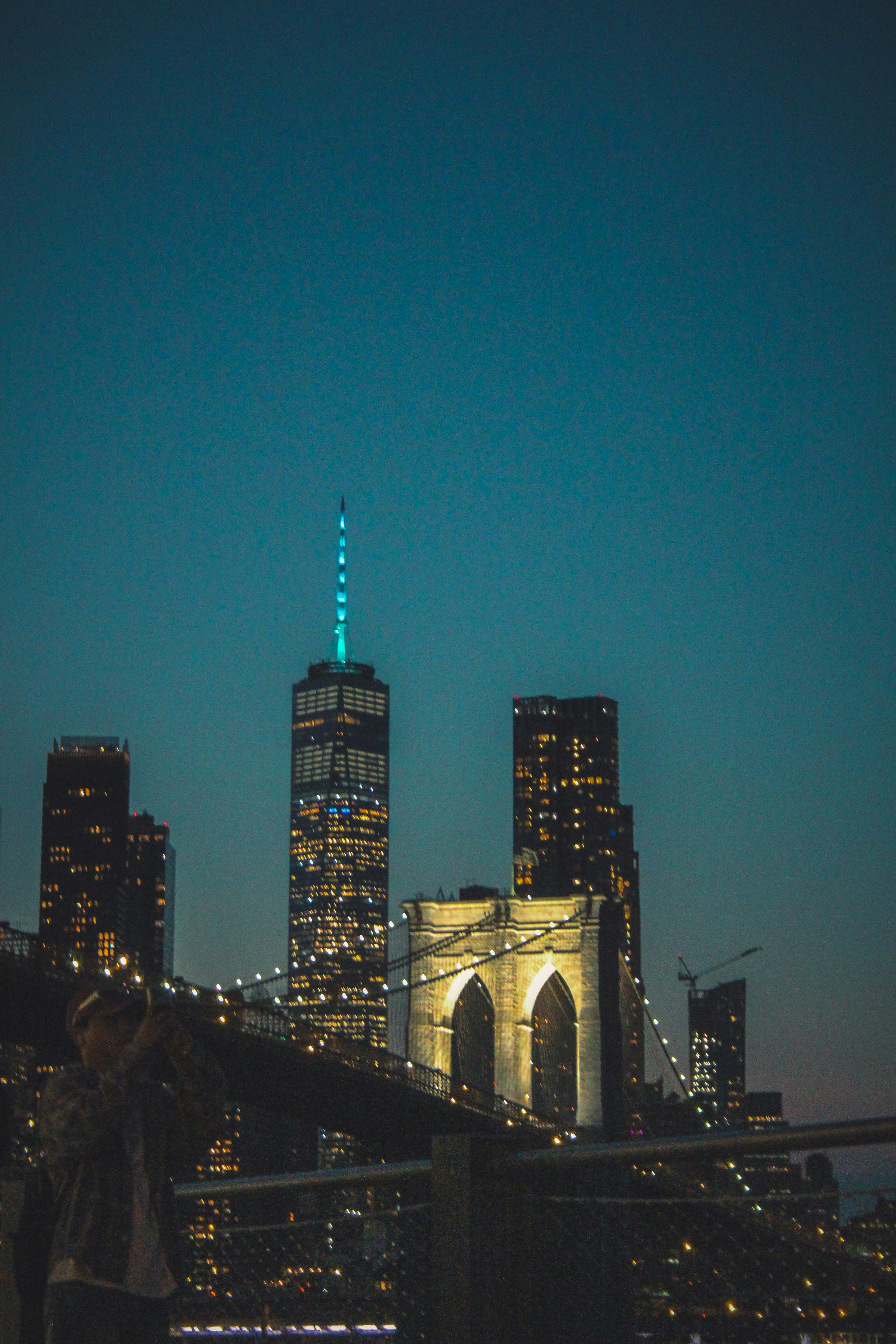 Cityscape at Dusk: Brooklyn Bridge and Manhattan Towers Silhouetted by Blue Sky