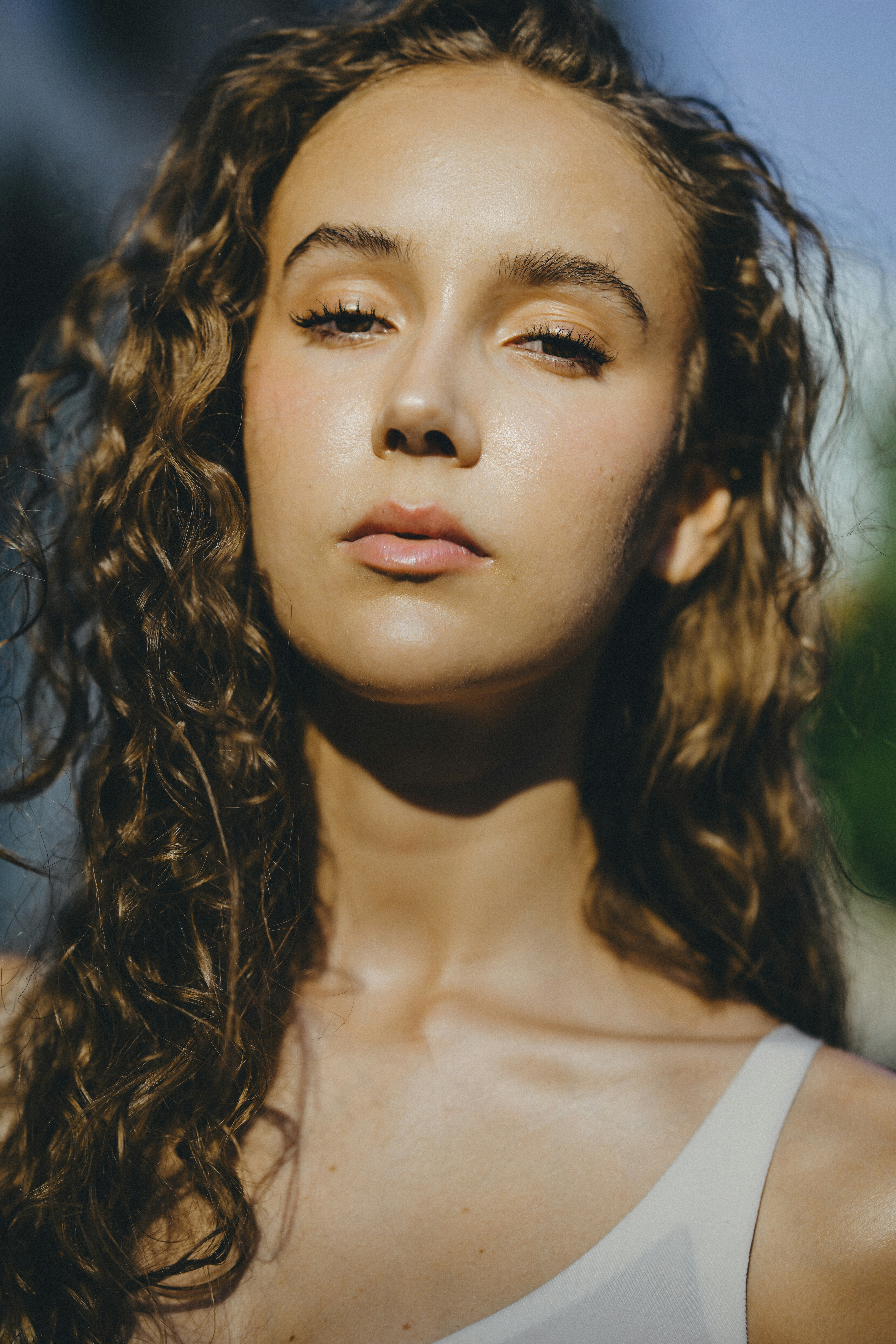Soft Sunlit Gaze: Portrait of a Curly-Haired Woman