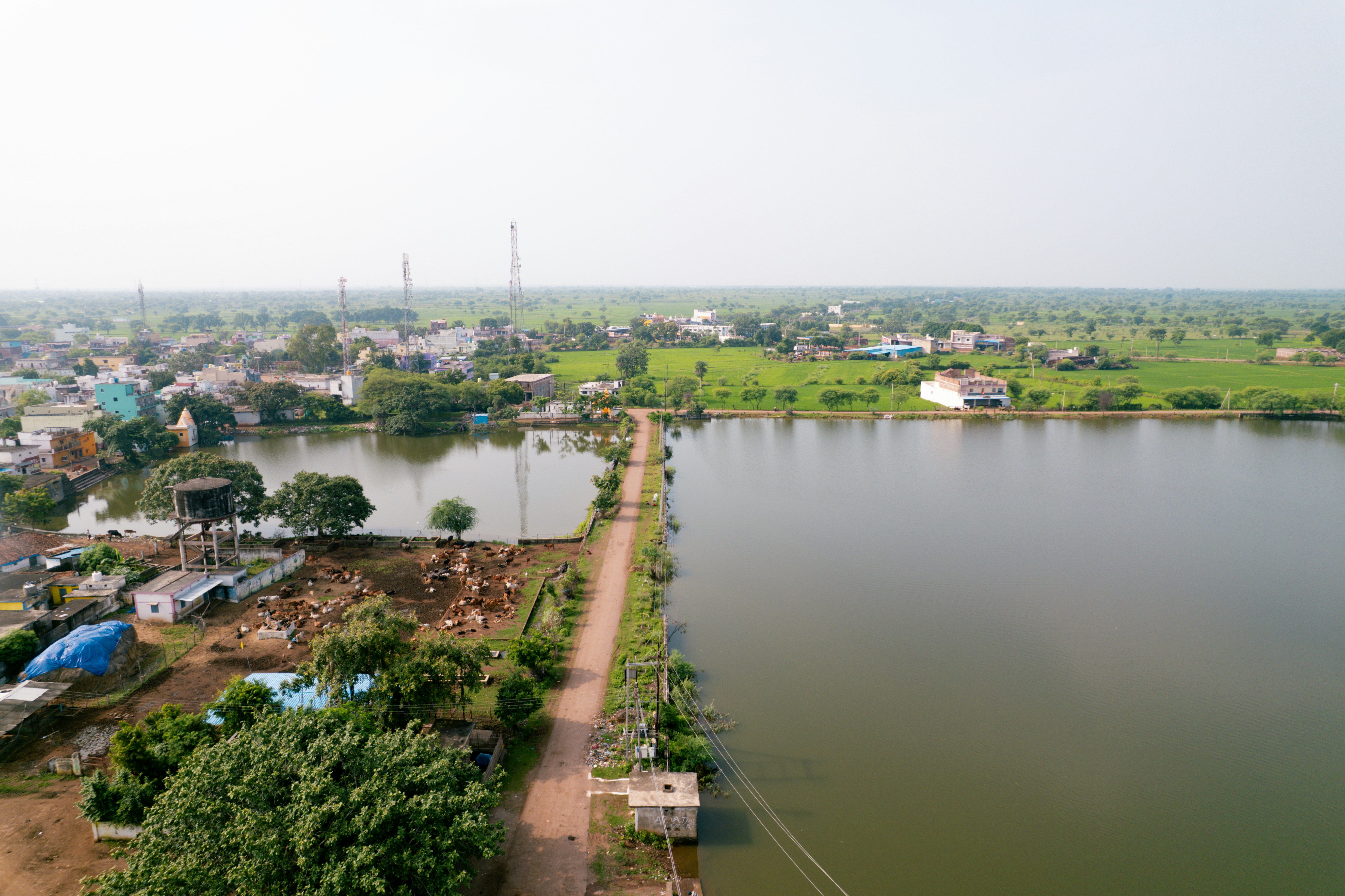 Aerial Crossroads: River, Road, and Village in Quiet Noon Light