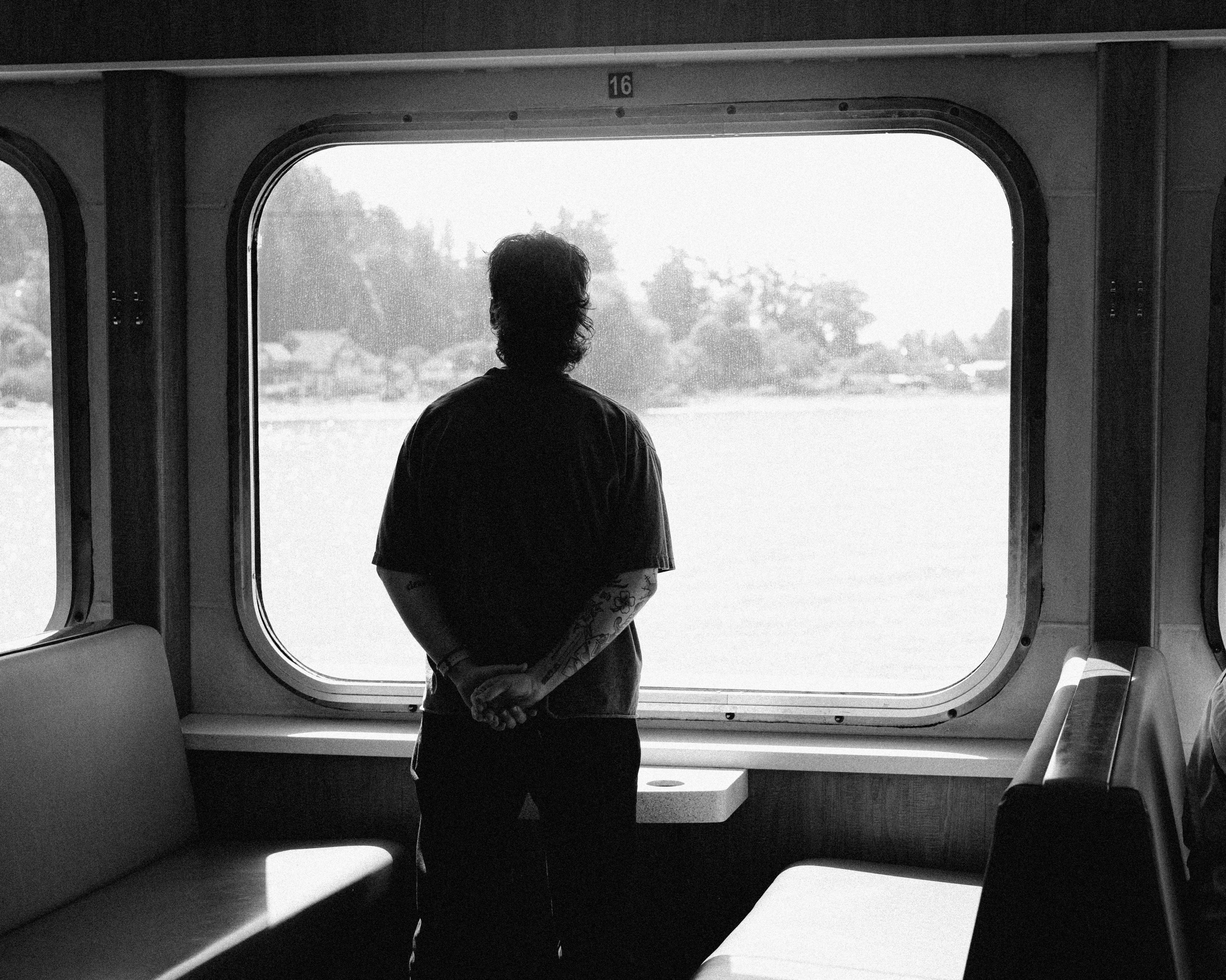 Silhouette at the Window: A figure gazing toward the shore