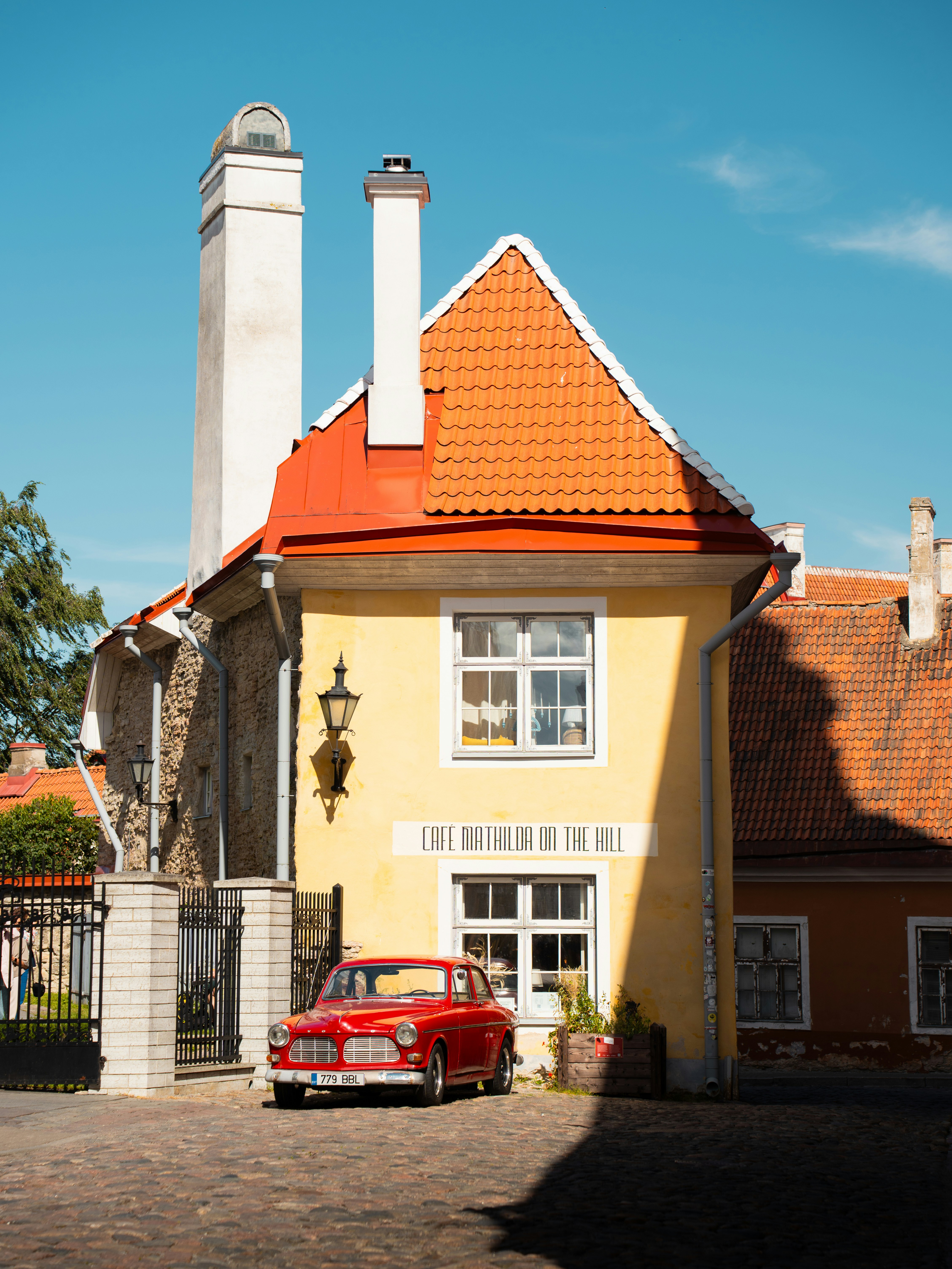 Cottage Email: A Sunny Village Facade with Red Roof and Vintage Car