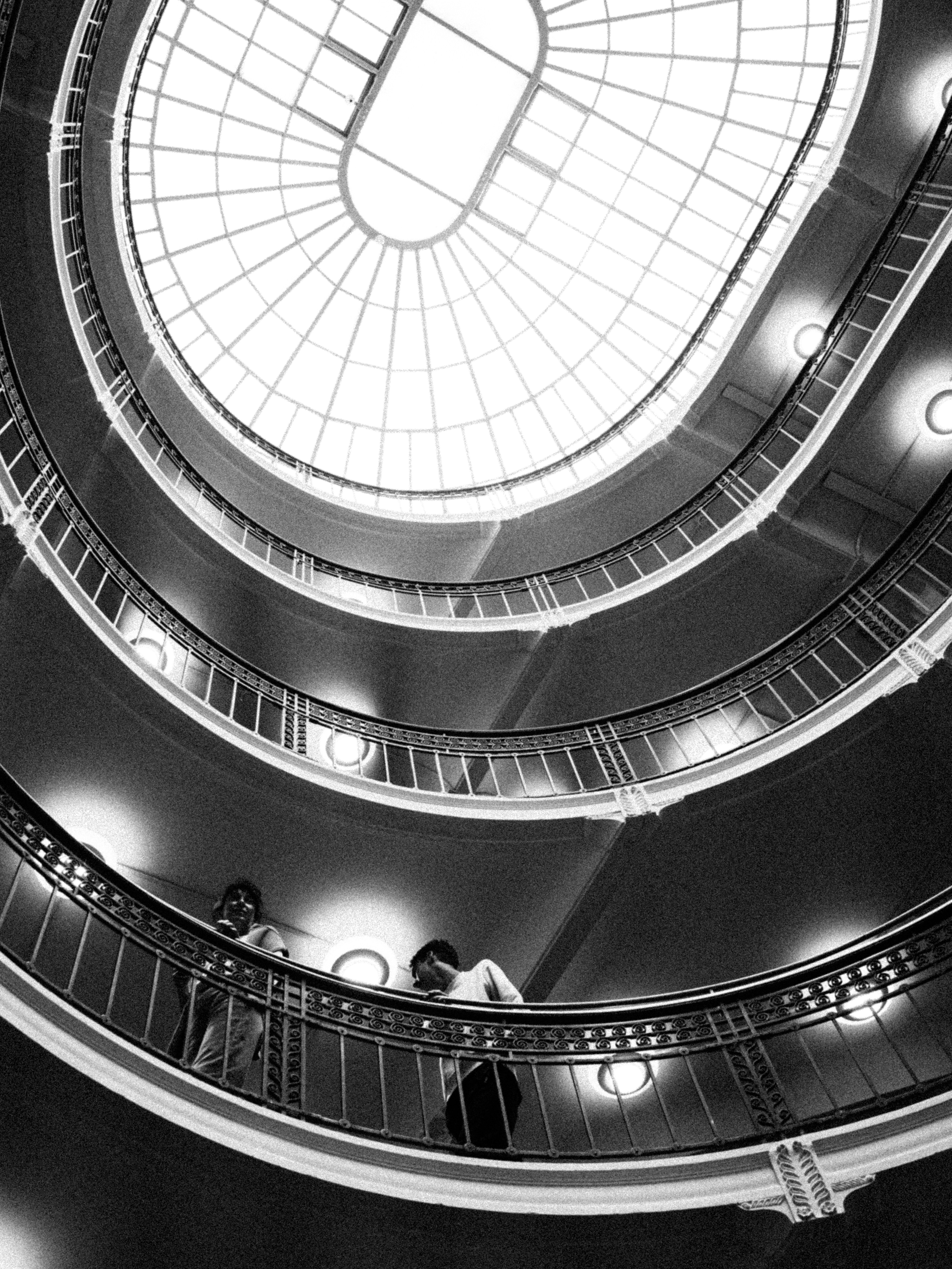 Spiral Atrium: People Traversing the Circular Rails of an Interior Courtyard