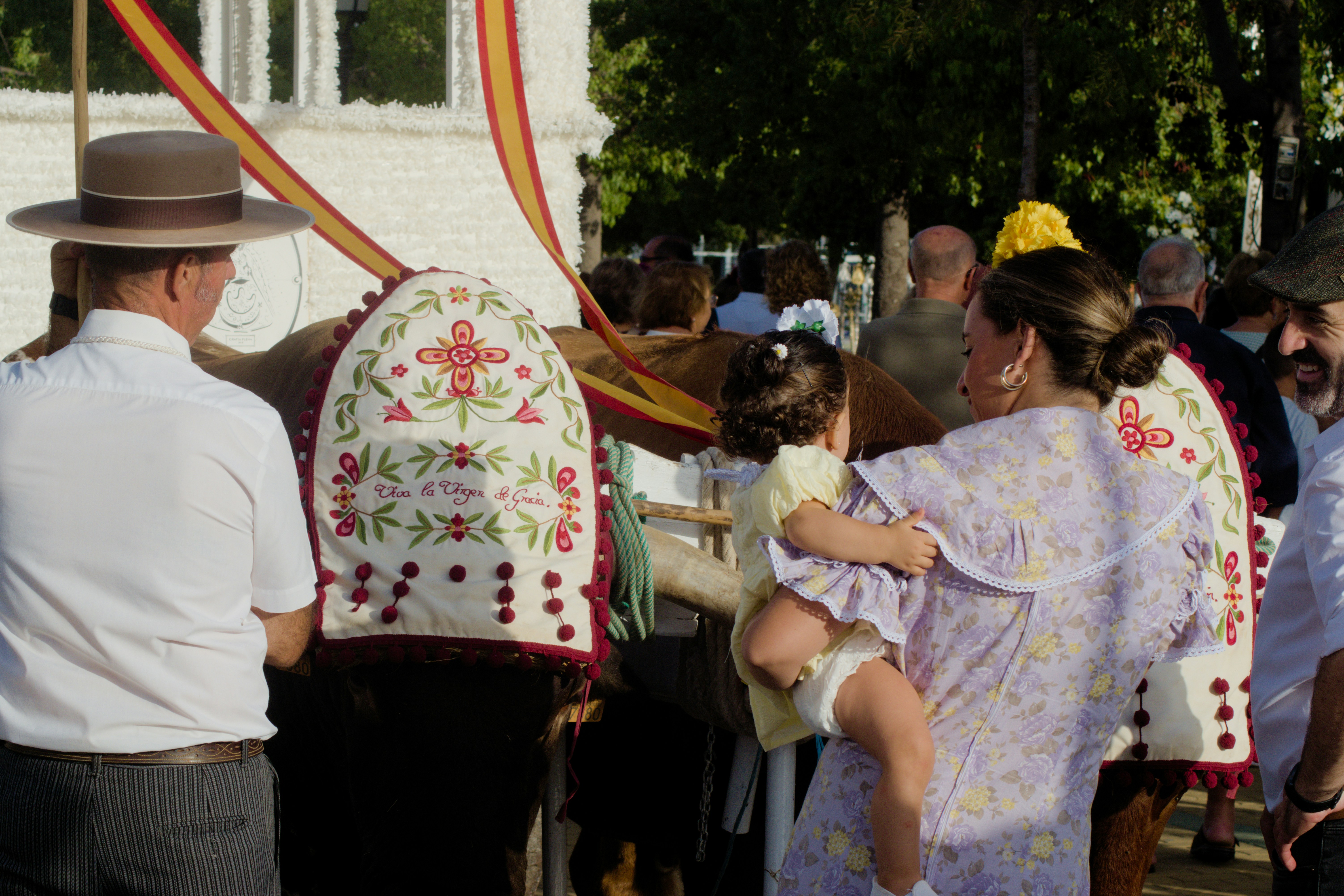Mother and Child Amid Colorful Carriages at a Festive Parade