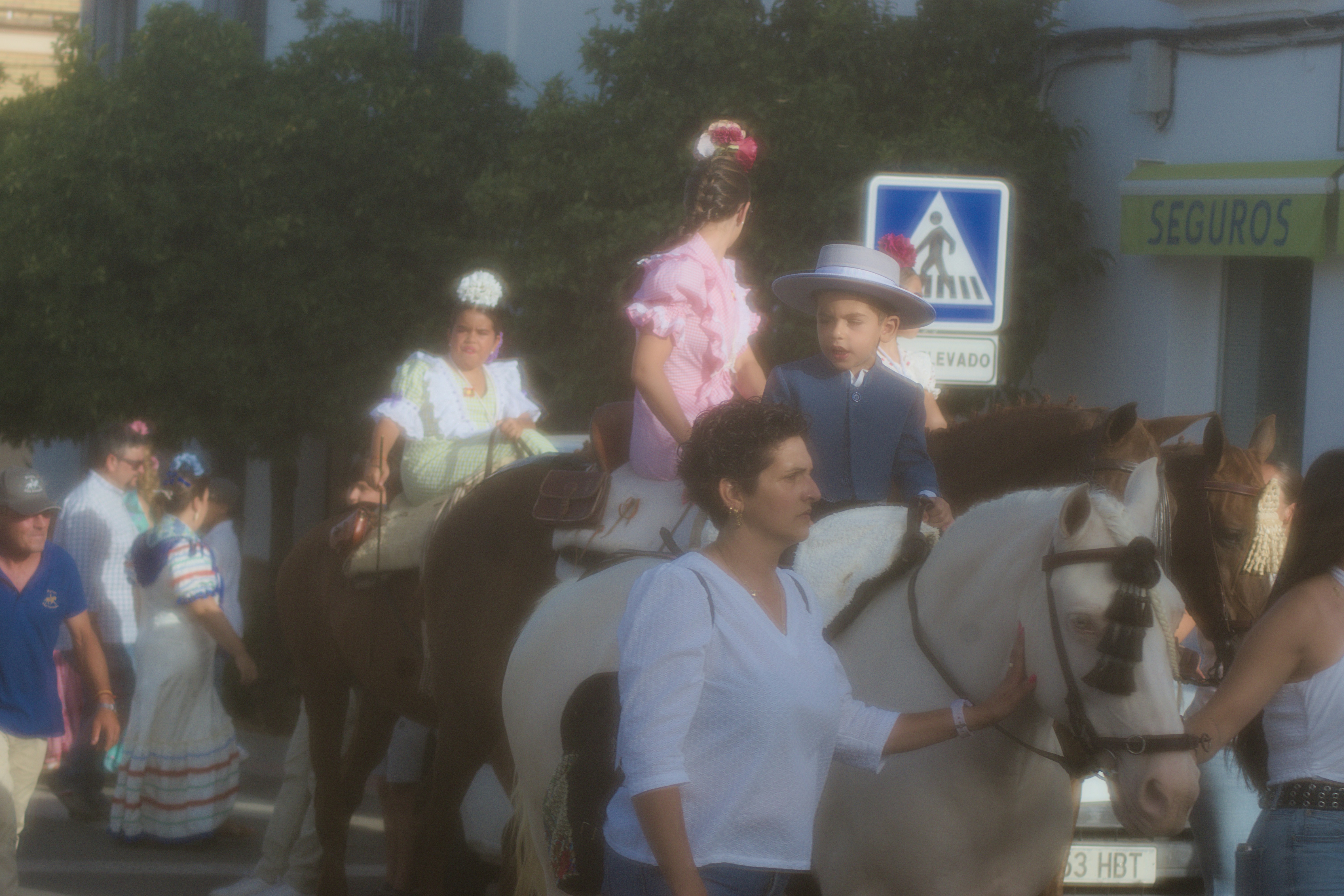 Parade Riders and Spectators in a Sunlit Street
