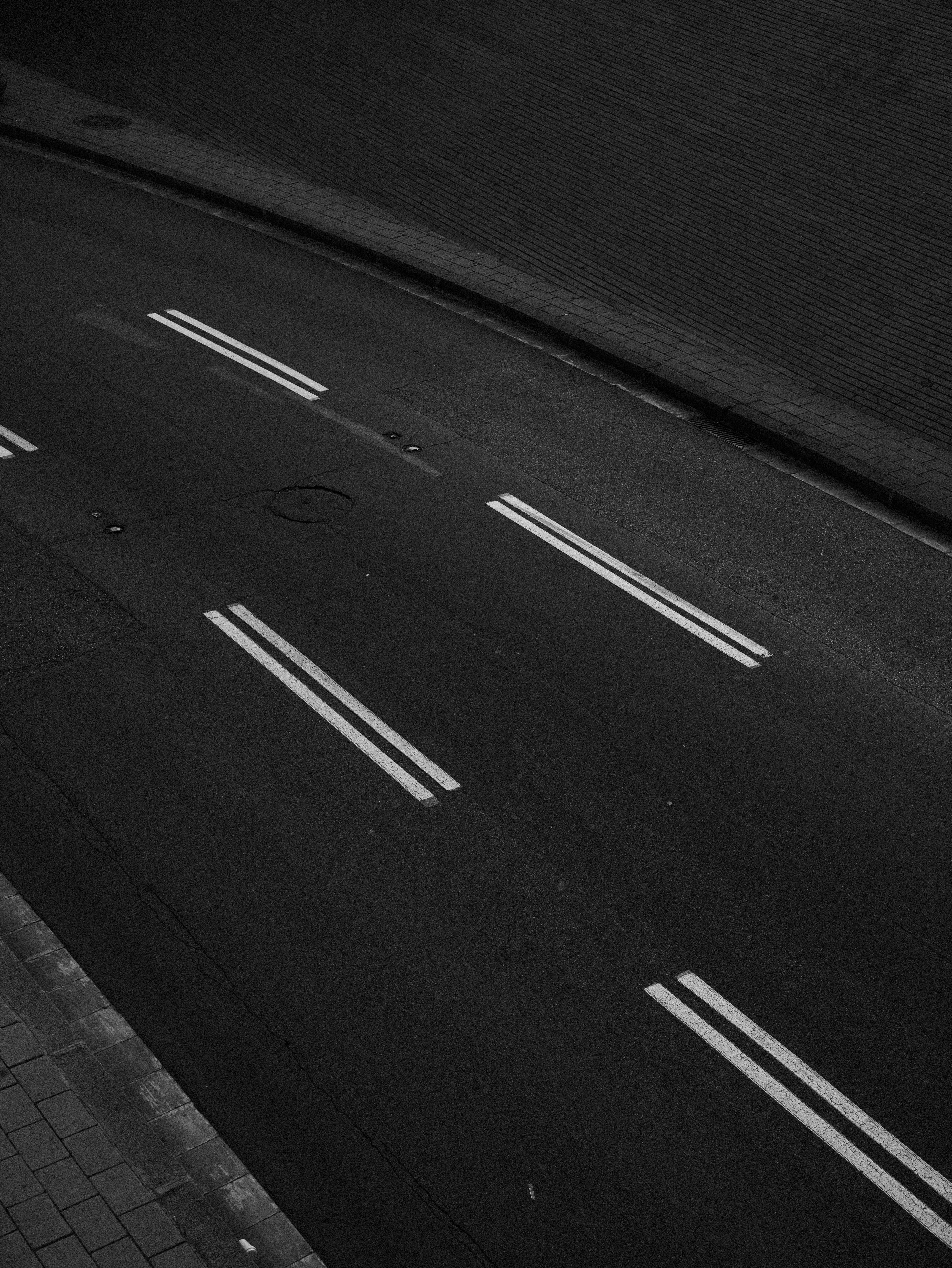 Overhead Midnight Road: Painted Stripes in Quiet Asphalt