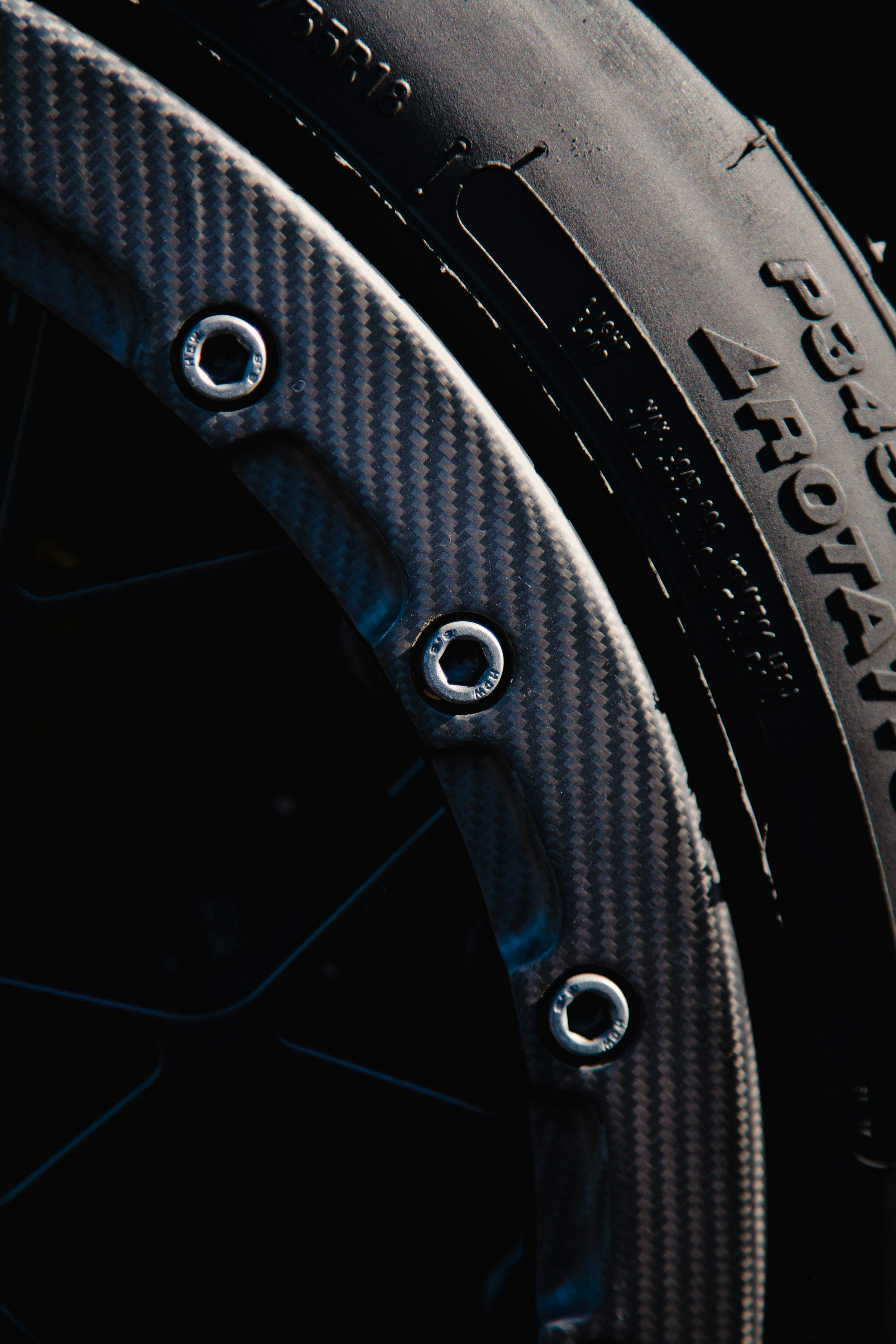Carbon Ring: Close-Up of a Carbon-Wrapped Wheel Rim and Fastener Detail