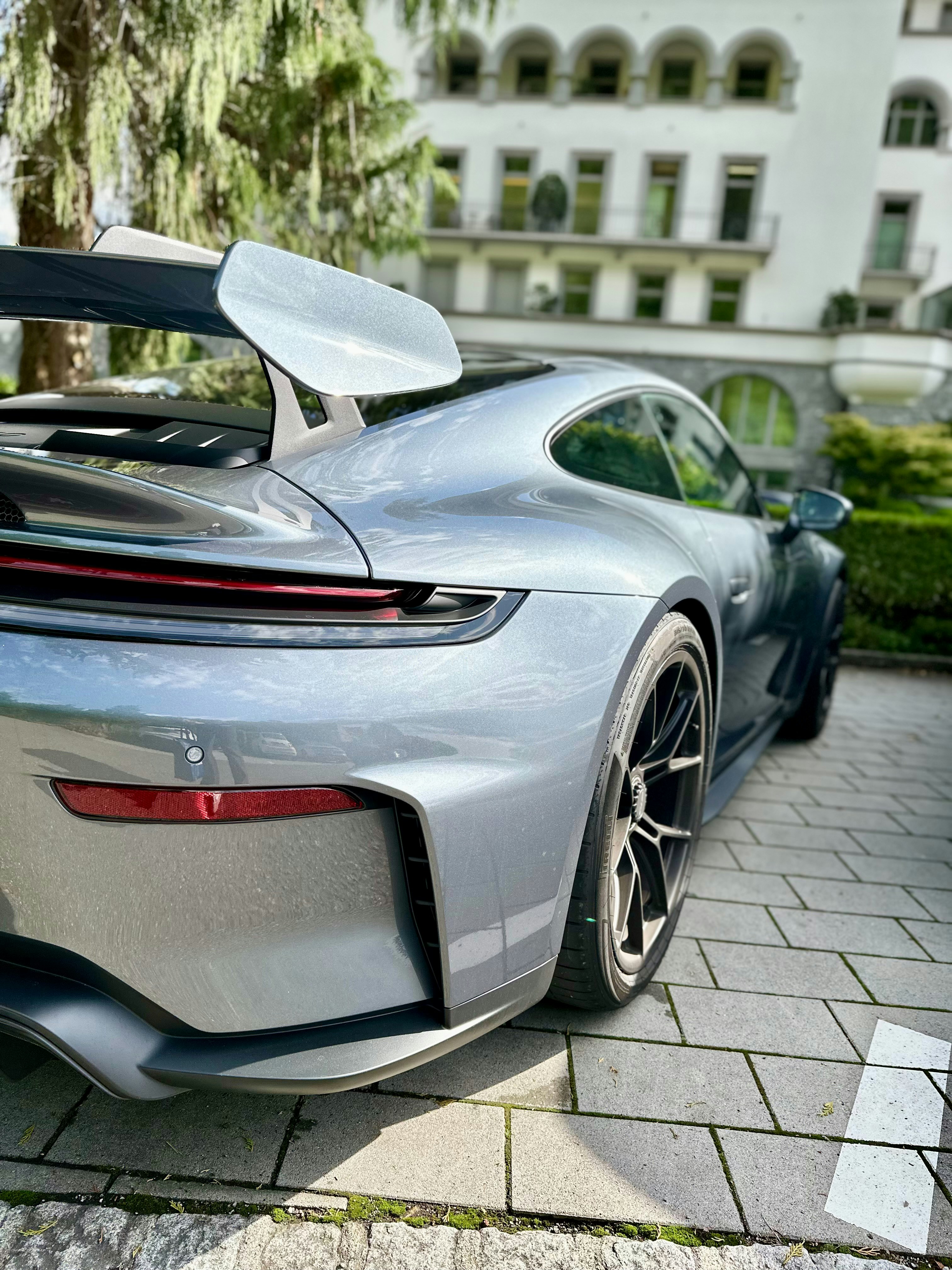 Silver Ferrari-esque Sport Car: Side Profile and Rear Wing in a Courtyard