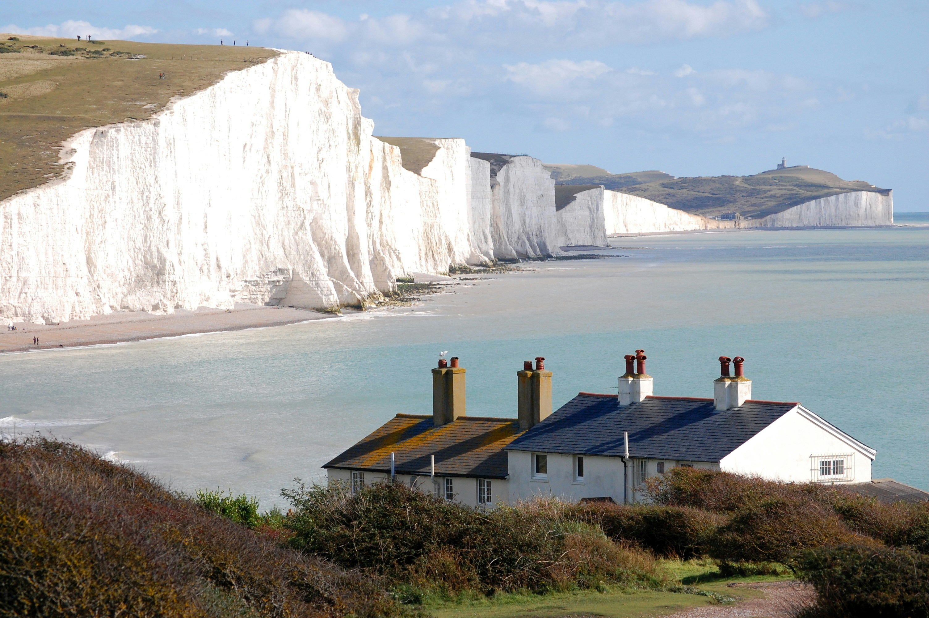 Chalk Cliffs and Seaside Cottages under a Coastal Sky
