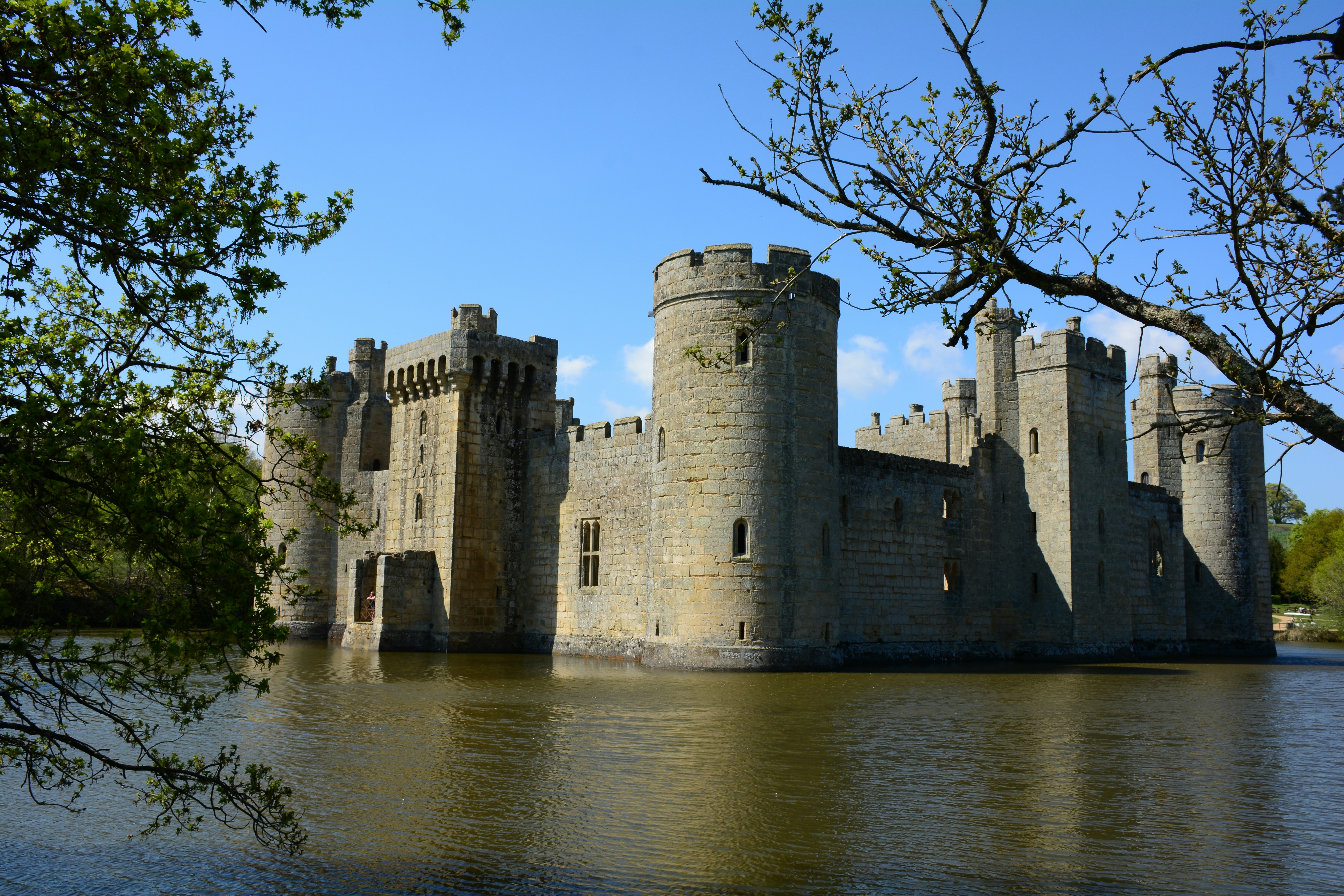 Castle on the Still Waters: A Brick Fortress Framed by Willow Arches