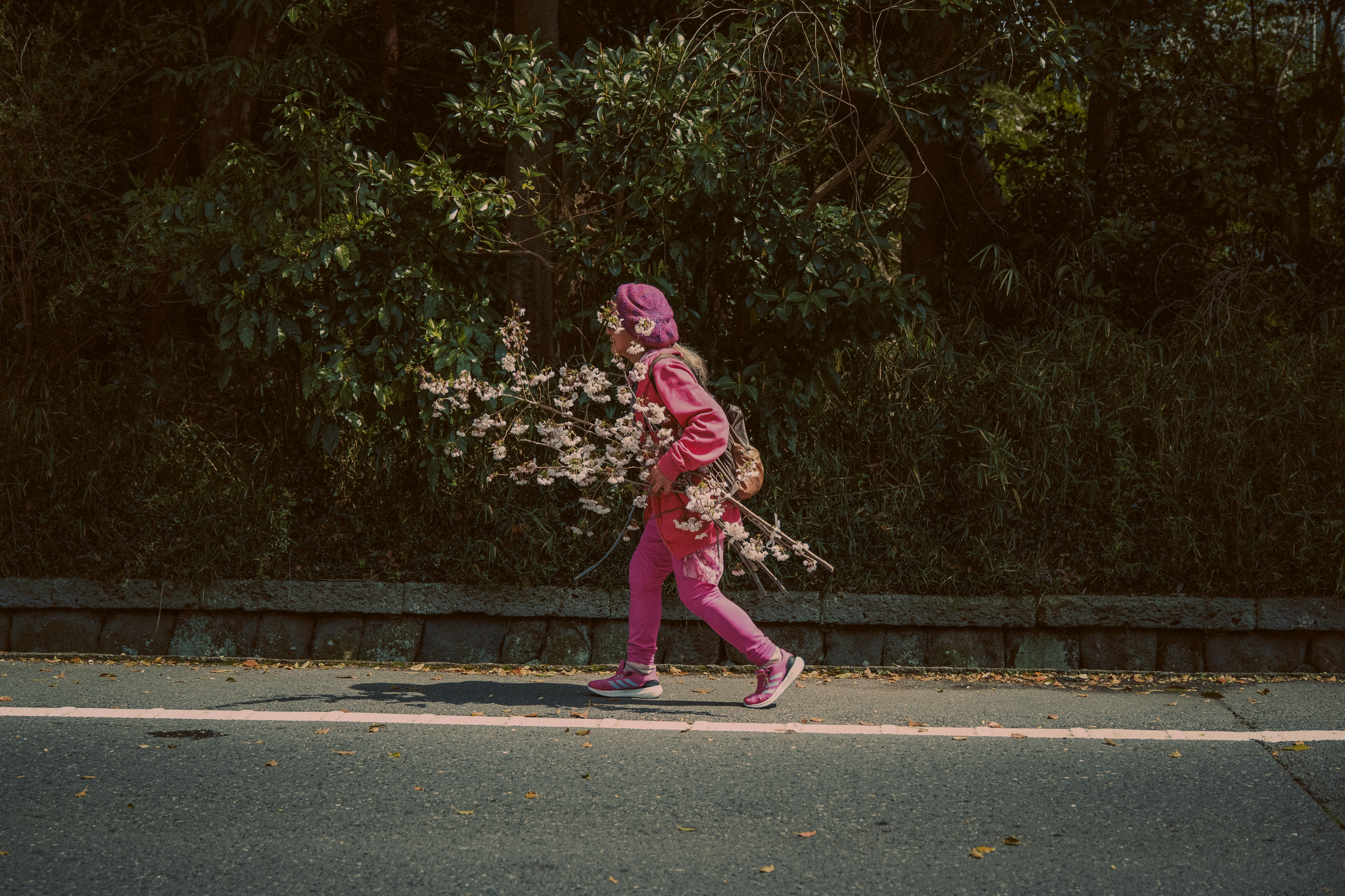 Pink-clad Child Walking Along a Quiet Road