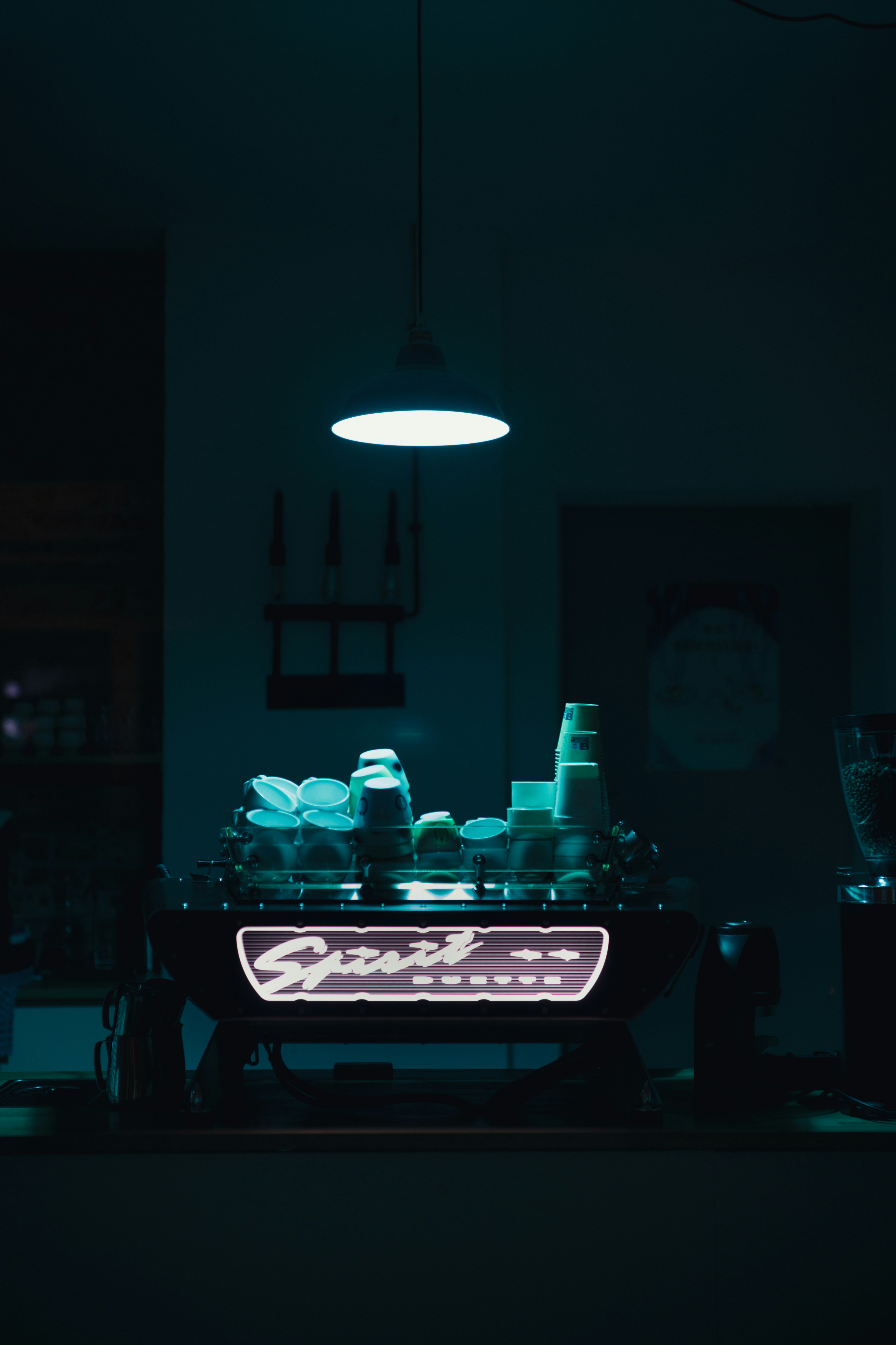 Neon-lit Espresso Bar: Stacks and Steam Under a Single Pendant