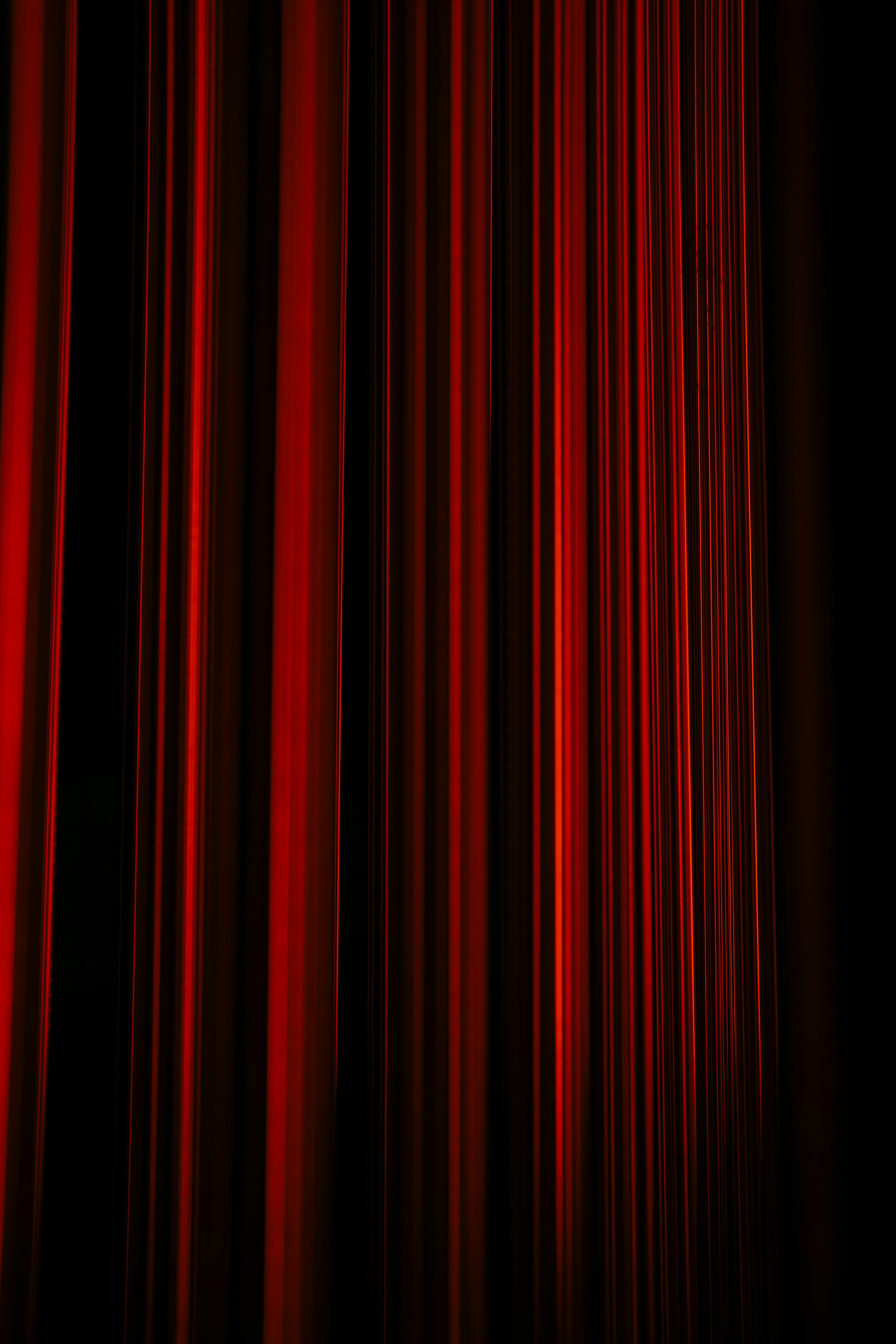 Vertical Red Streams: A Pulse of Neon Curtain Shadows