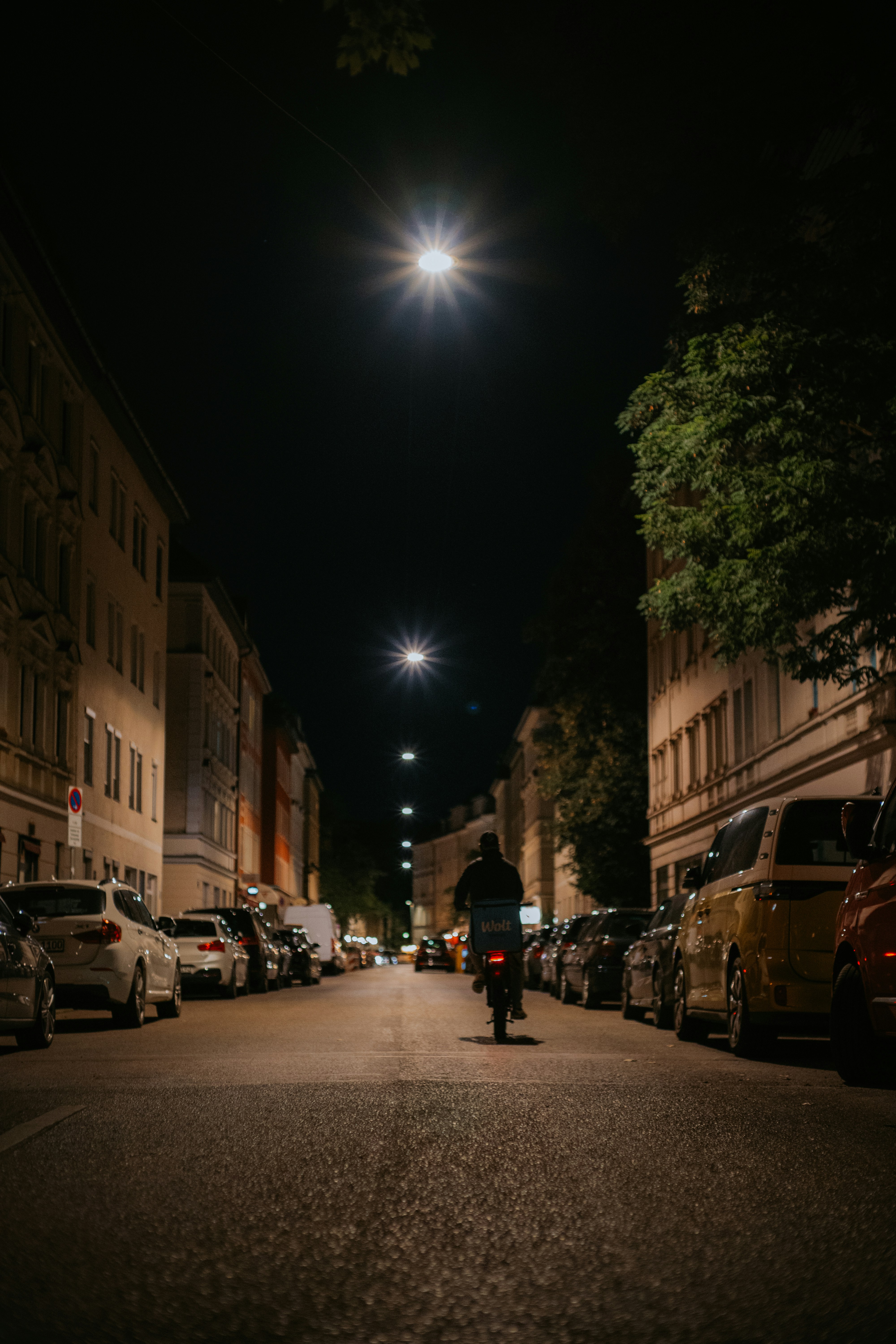 Midnight Corridor: a lone cyclist under city glow