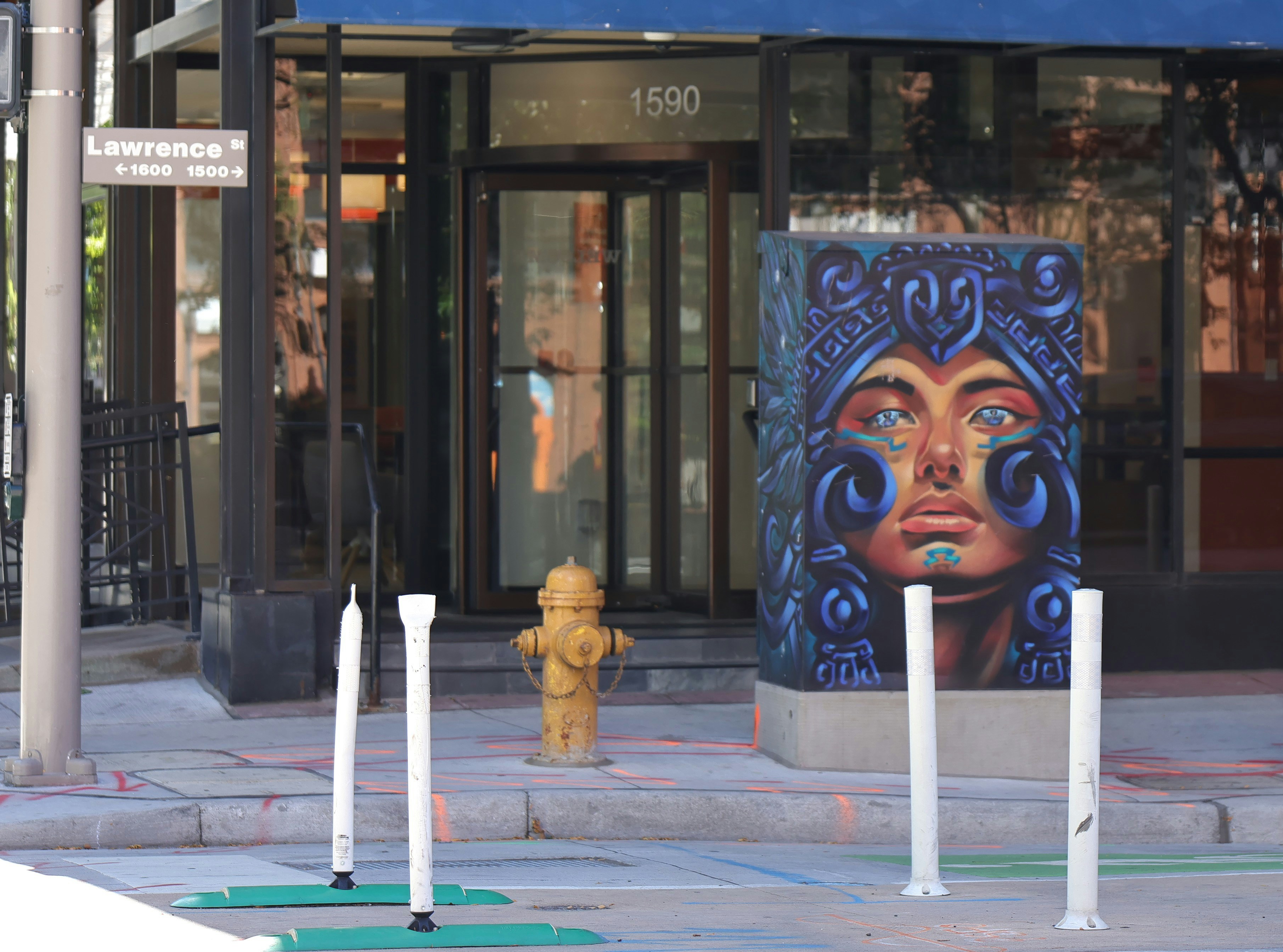 Blue-Masked Gaze: Street Art Portrait by the Sidewalk