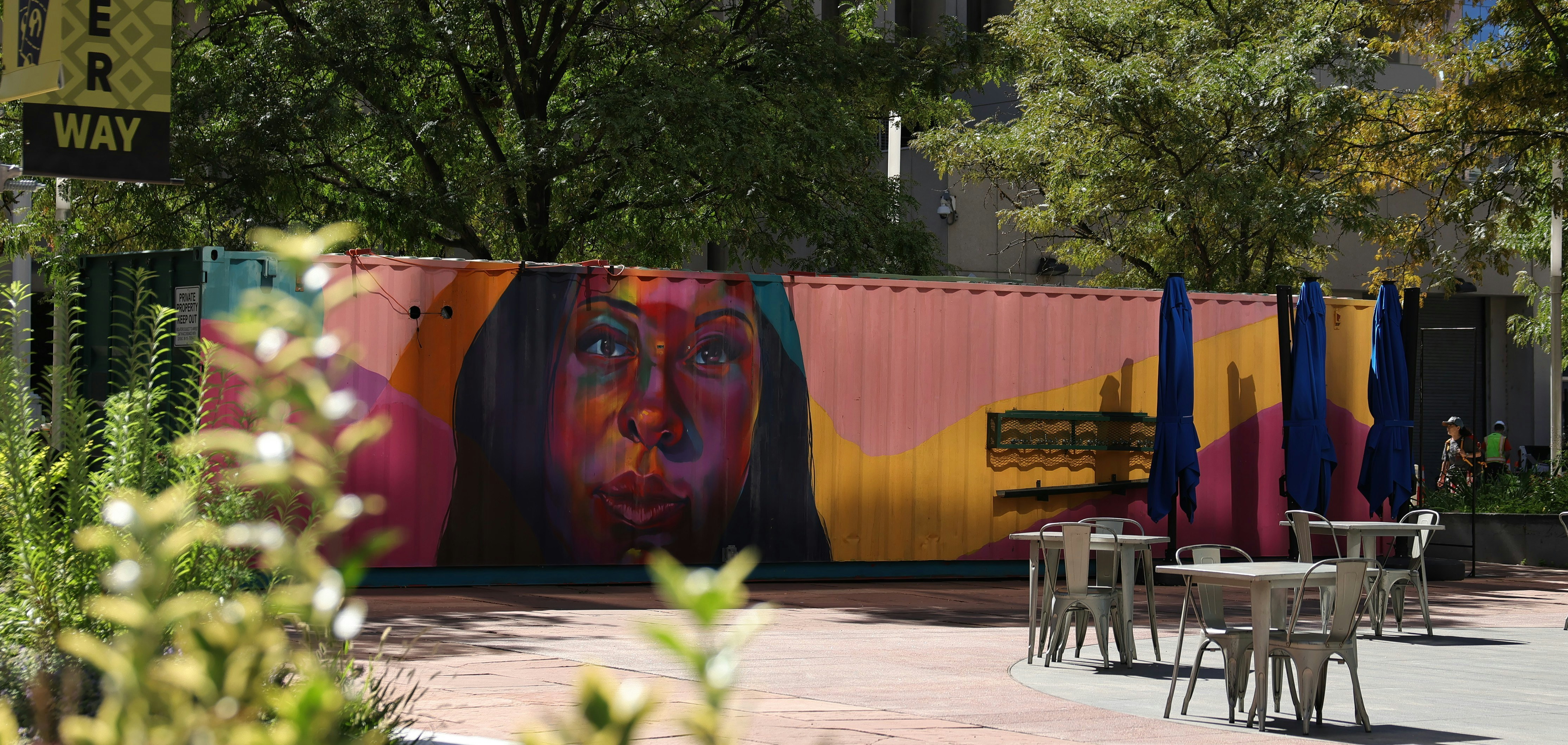 Colorful Portrait Wall: Street Art Adorning a Quiet Plaza