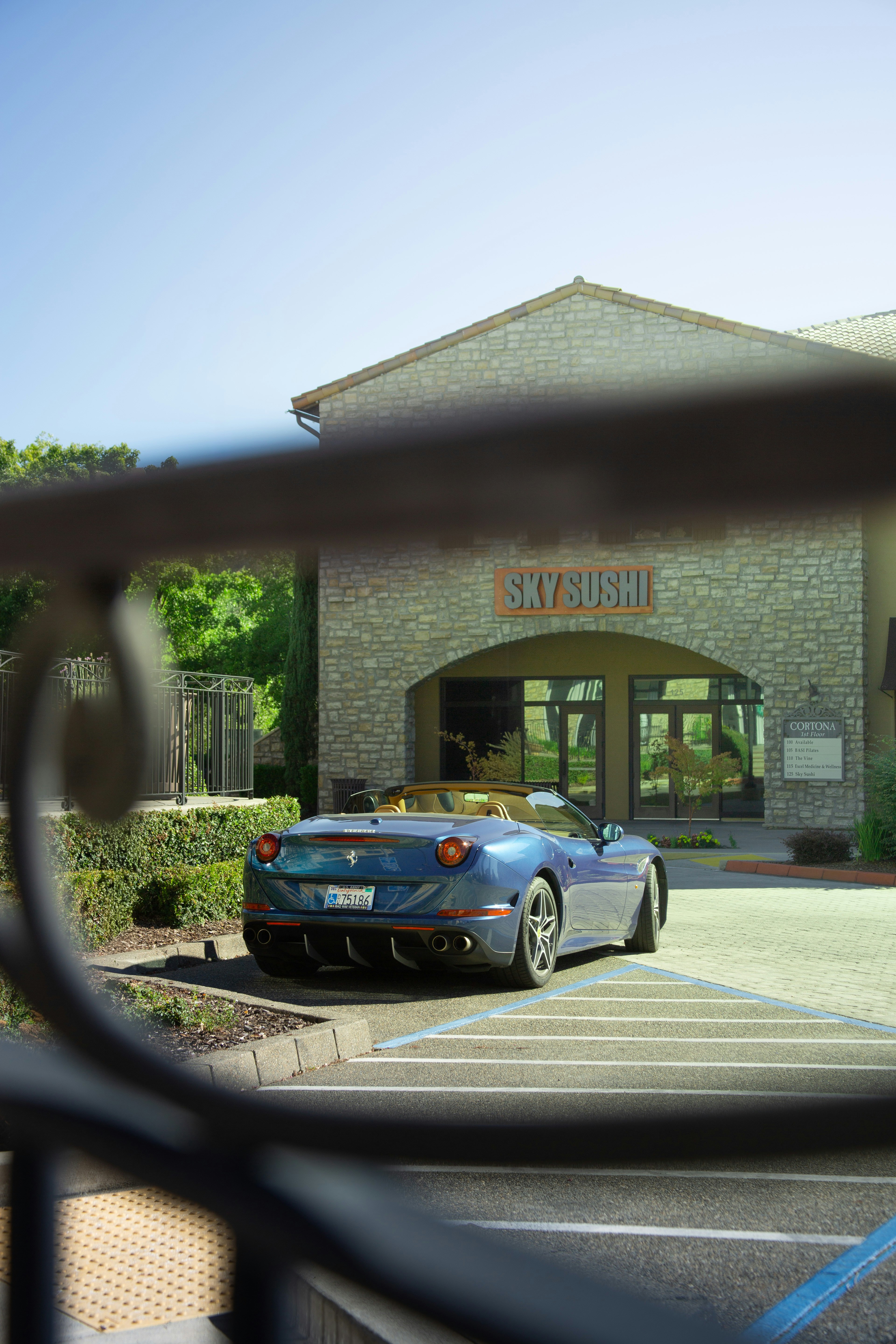 Blue Convertible at the Sky Sushi Drive: A slice of sunlit storefront and surroundings