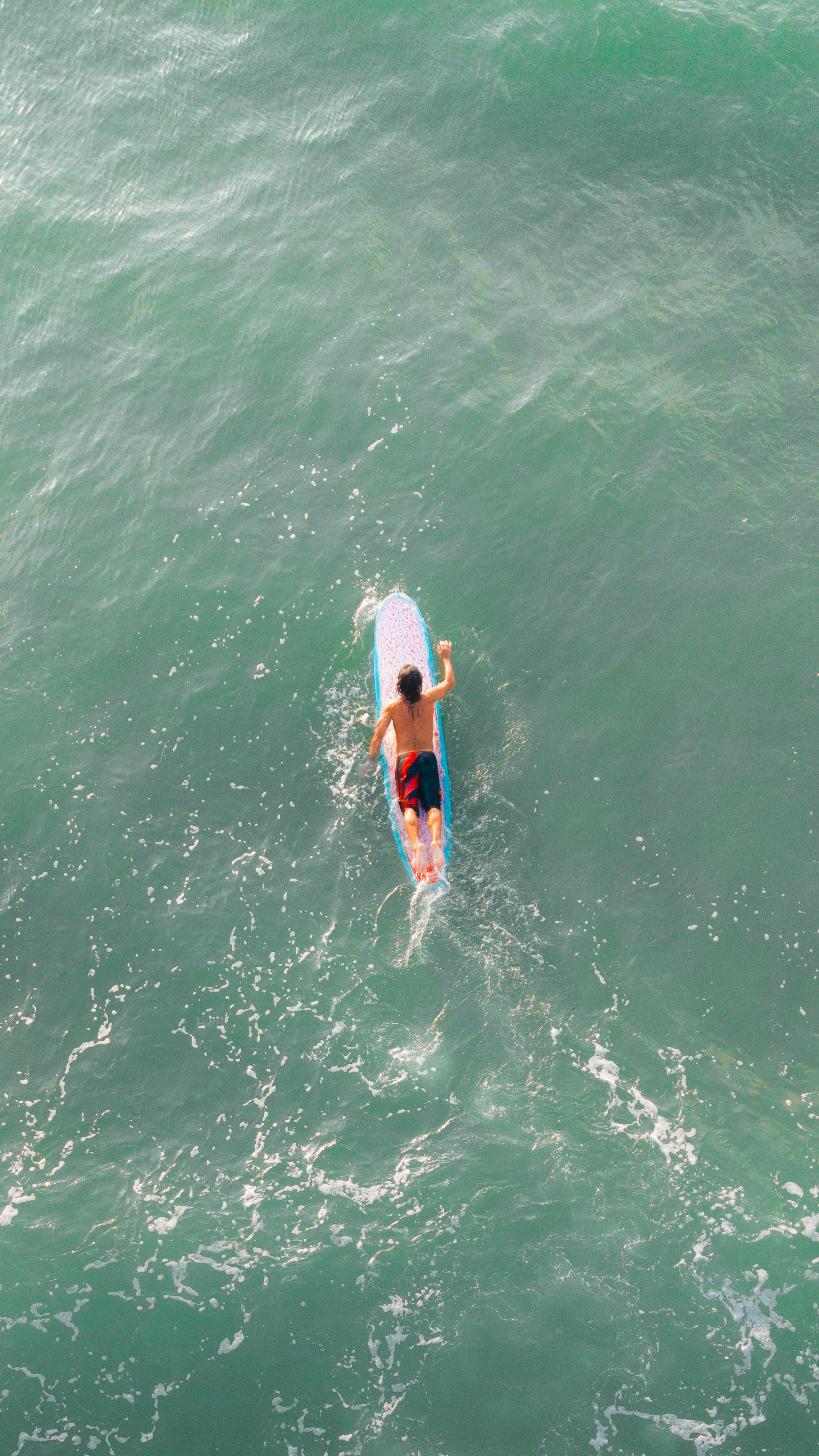 Surfing Silhouette: A lone rider slicing turquoise light