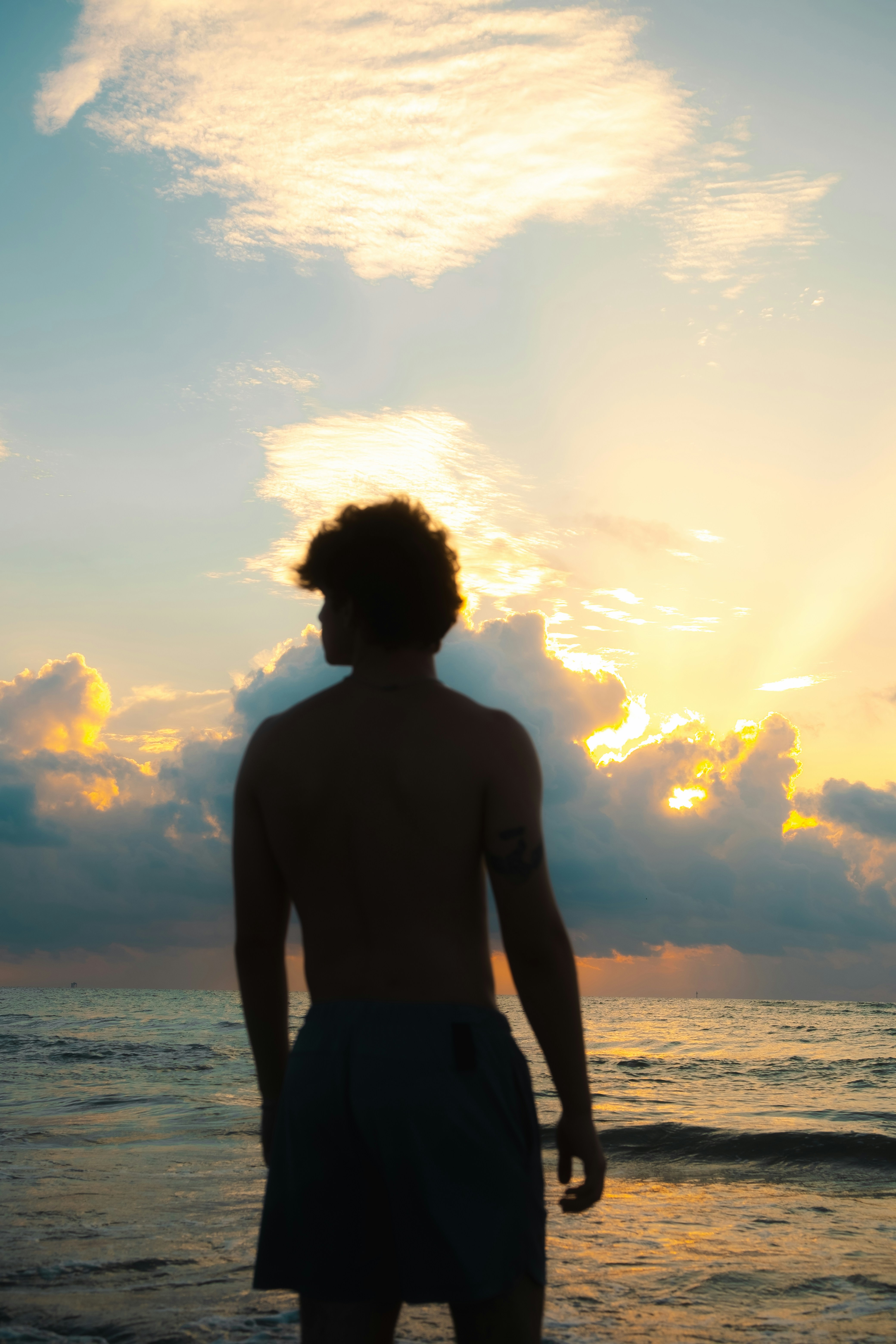 Sunset Silhouette: A Figure at the Edge of the Sea