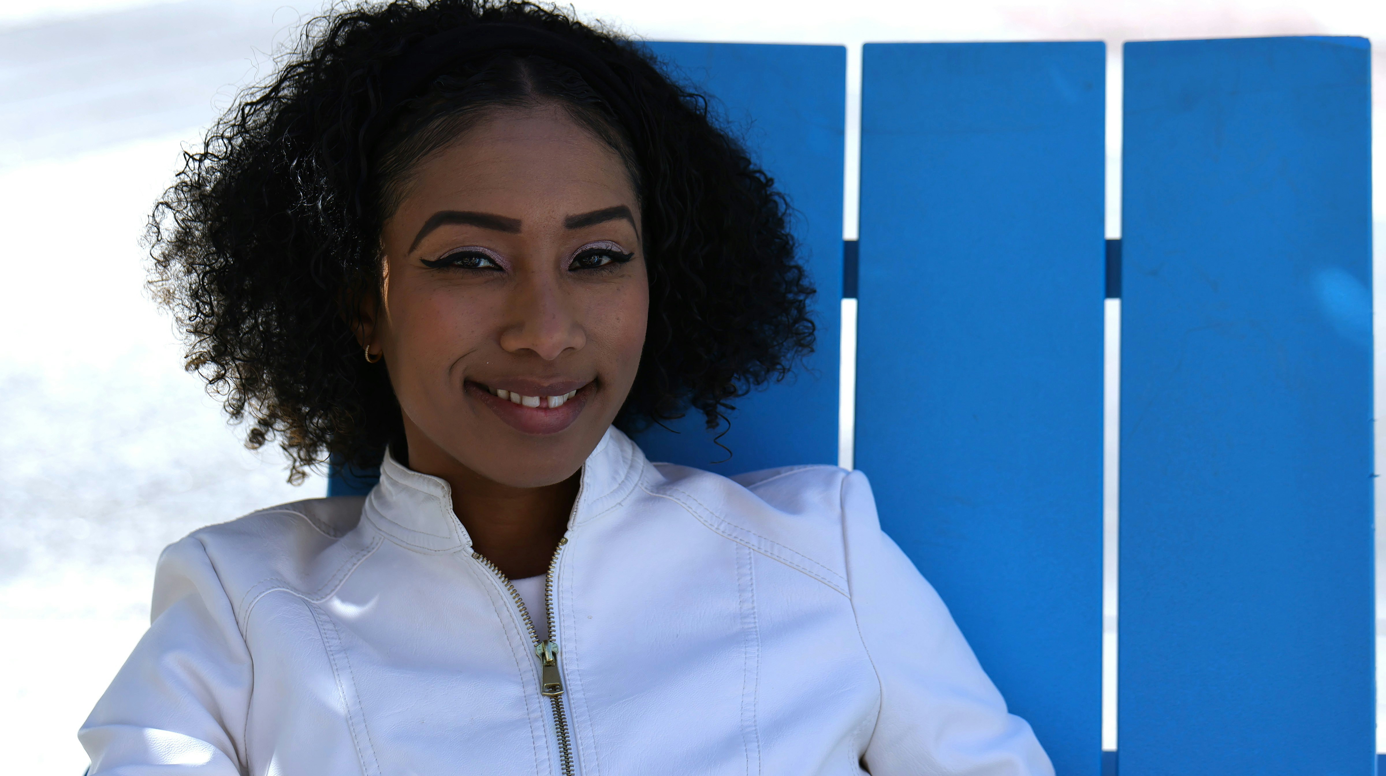 Cozy Confidence: A Portrait on a Bright Blue Bench
