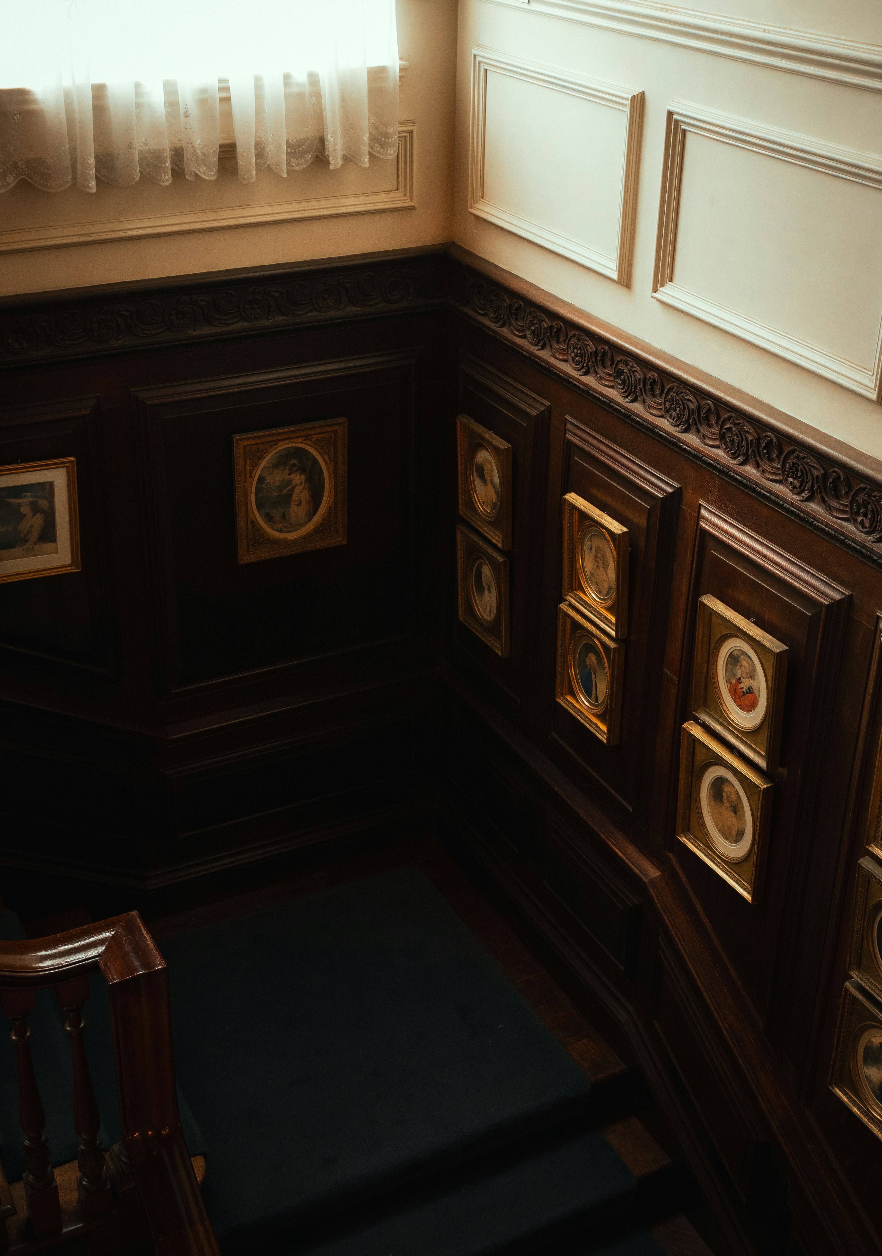 Heritage Gallery: Framed Portraits Along a Velvet-Walled Staircase