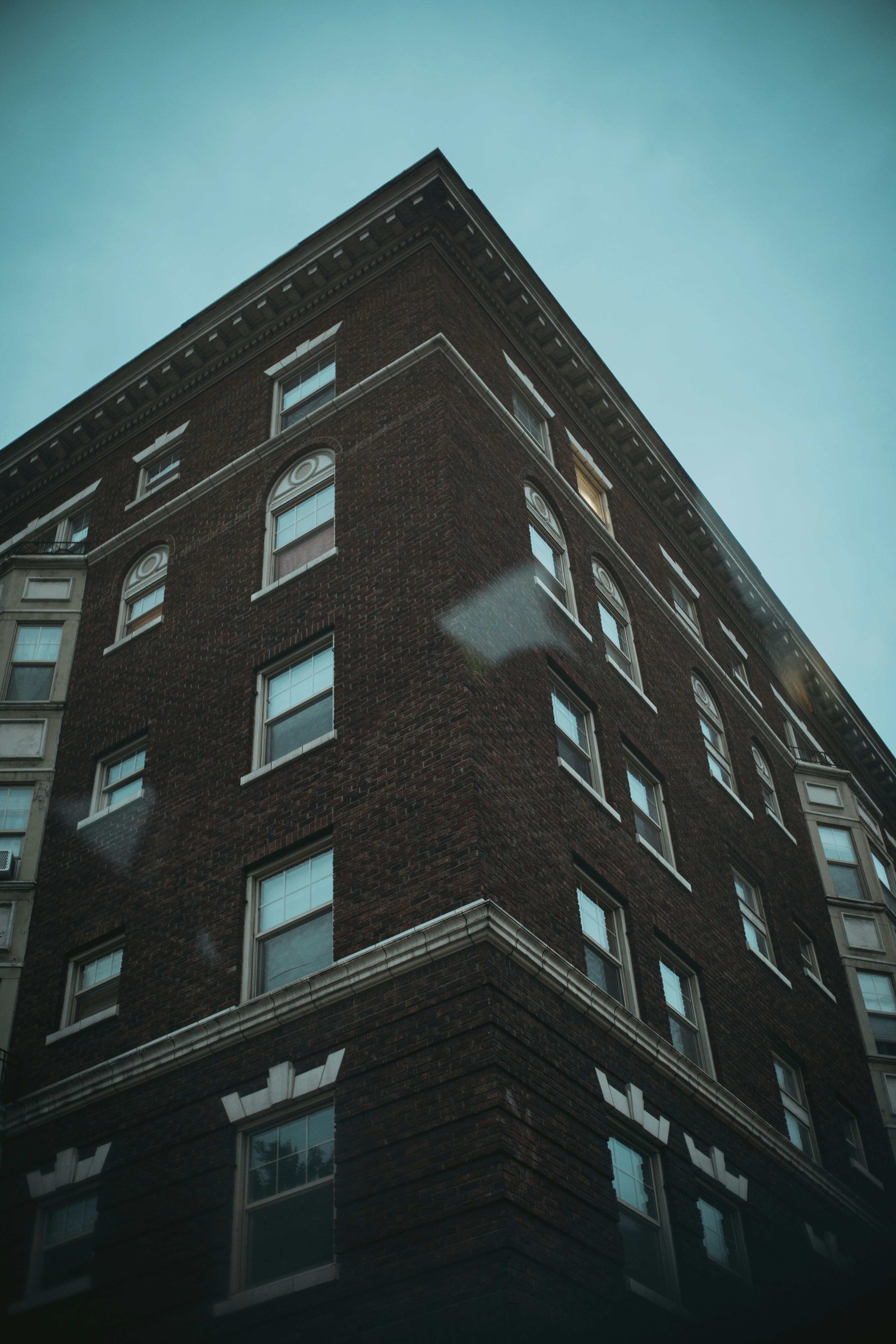 Cornered Grandeur: A Brick Facade Against a Cyan Sky