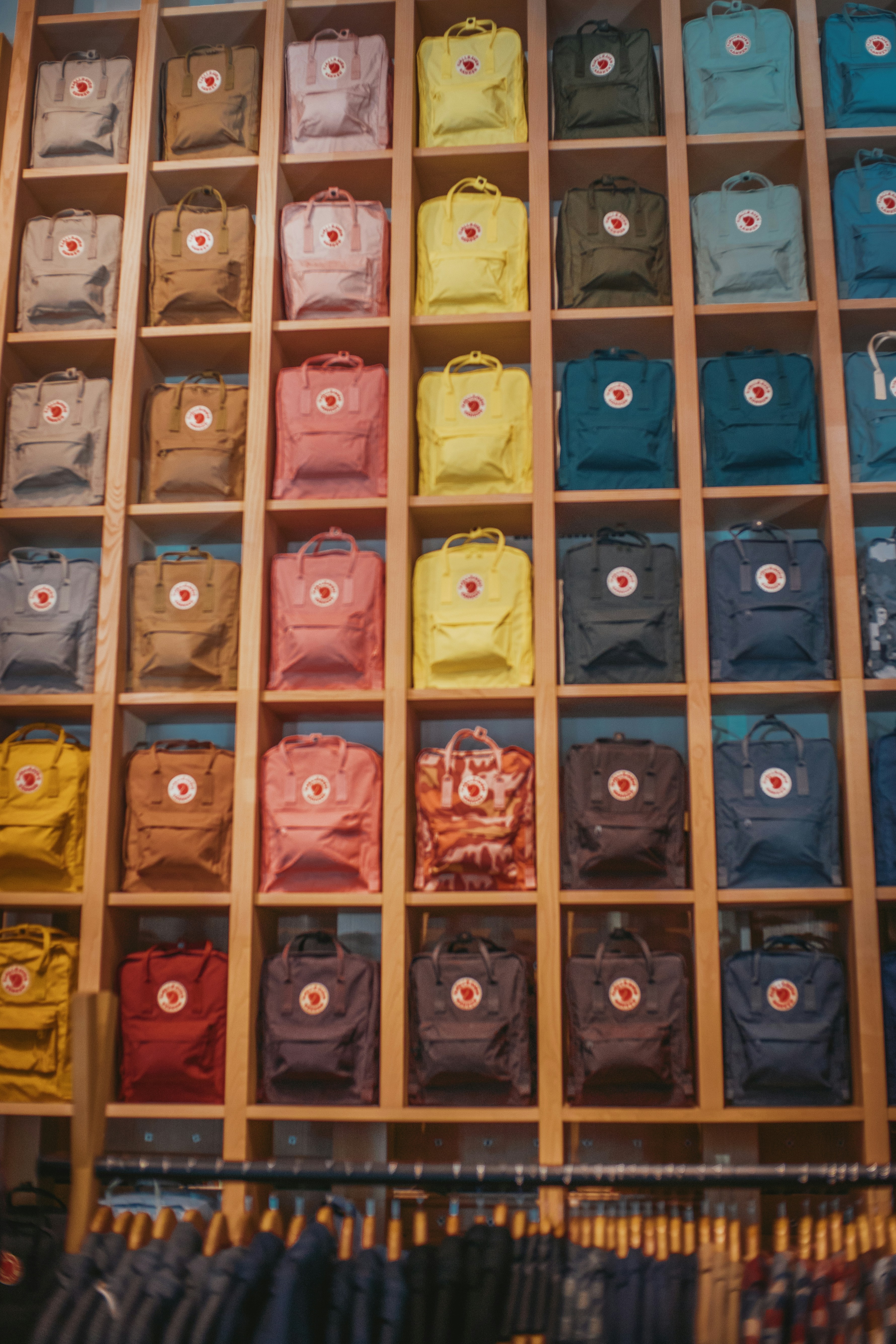 Color Grid of Mini Backpacks in a Wooden Cubby Display
