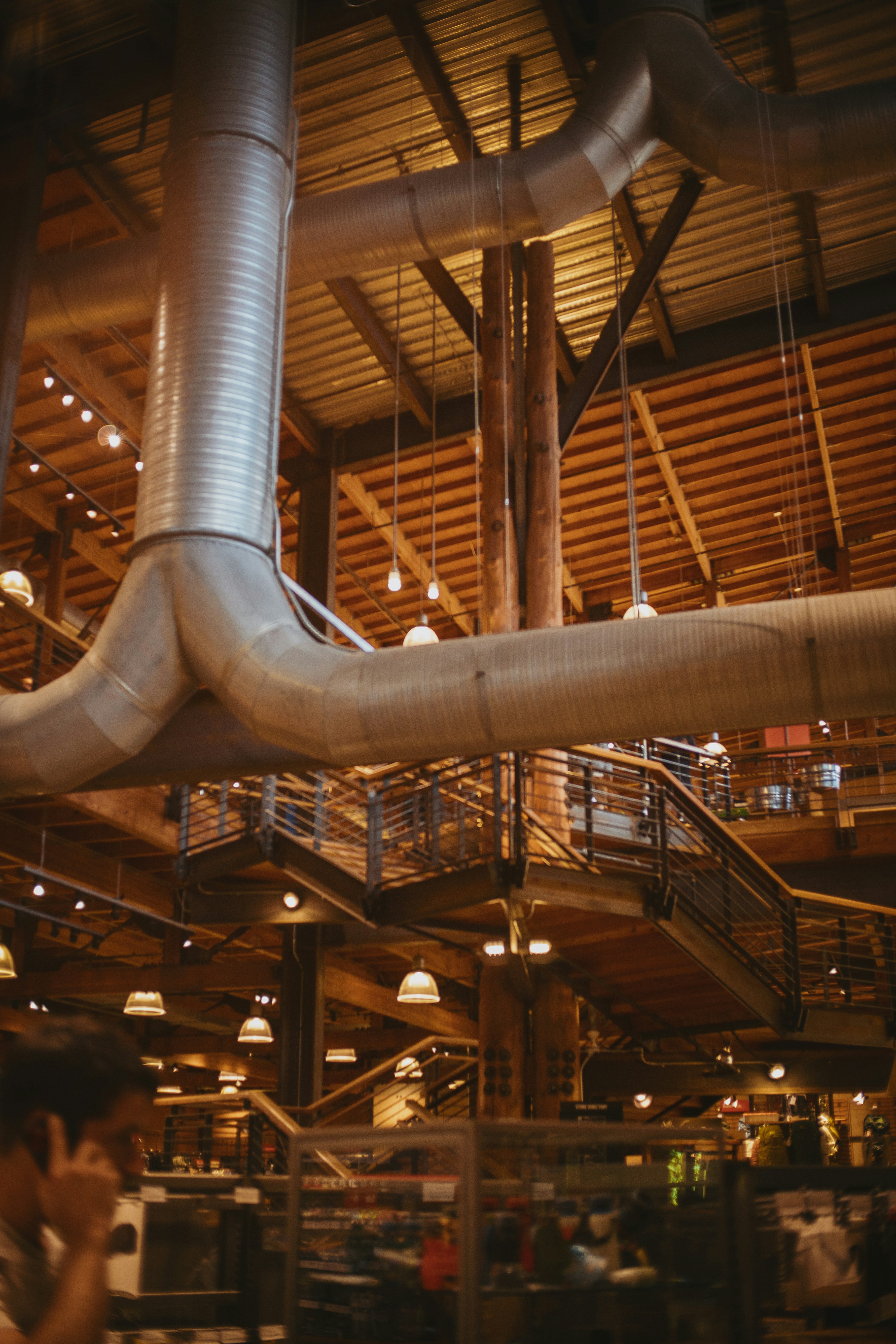 Industrial Lattice: A Spiral of Ducts in a Citrus-Warm Factory Interior