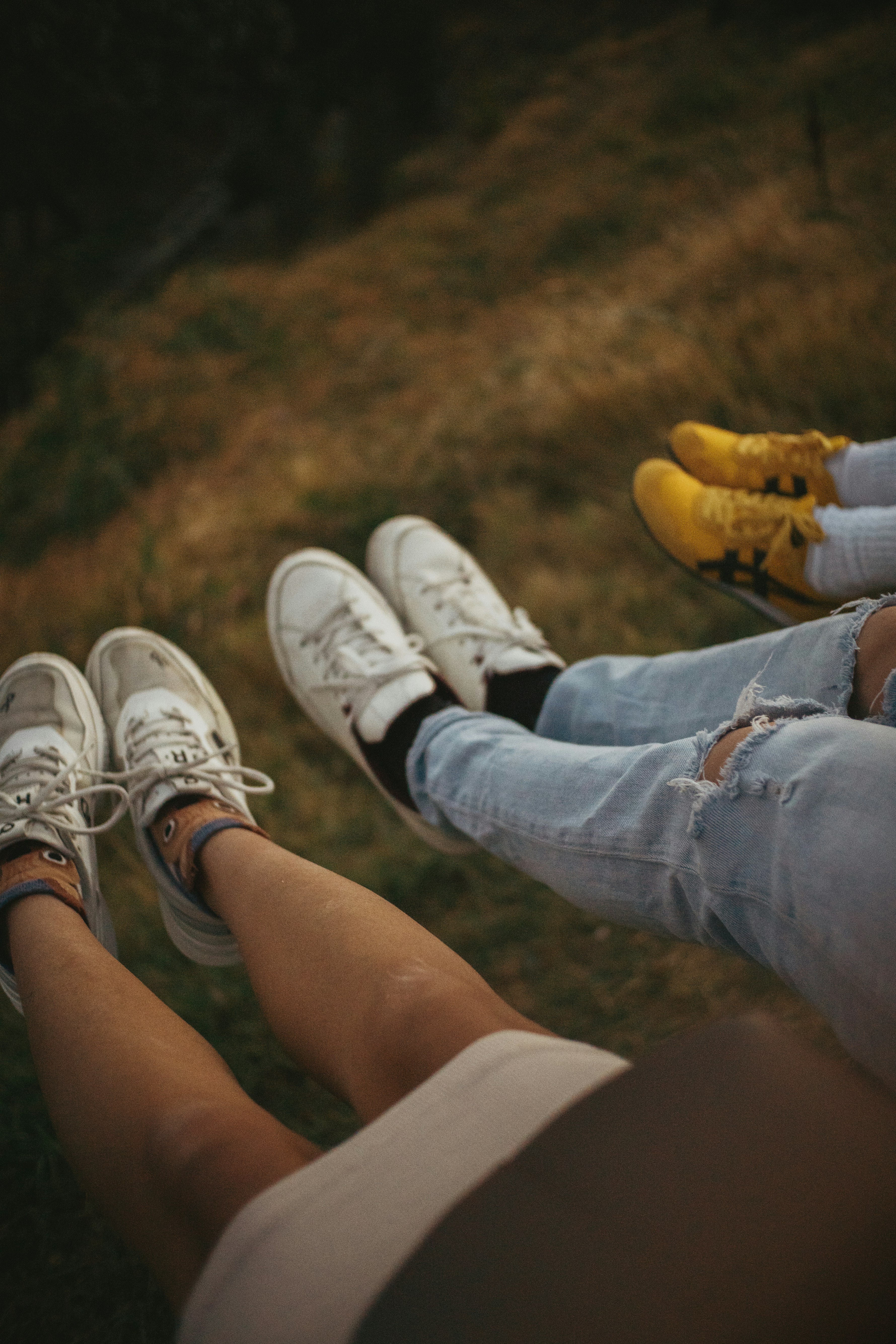 Triangle of Friends: Shoes and Jeans Swing Over a Golden Meadow