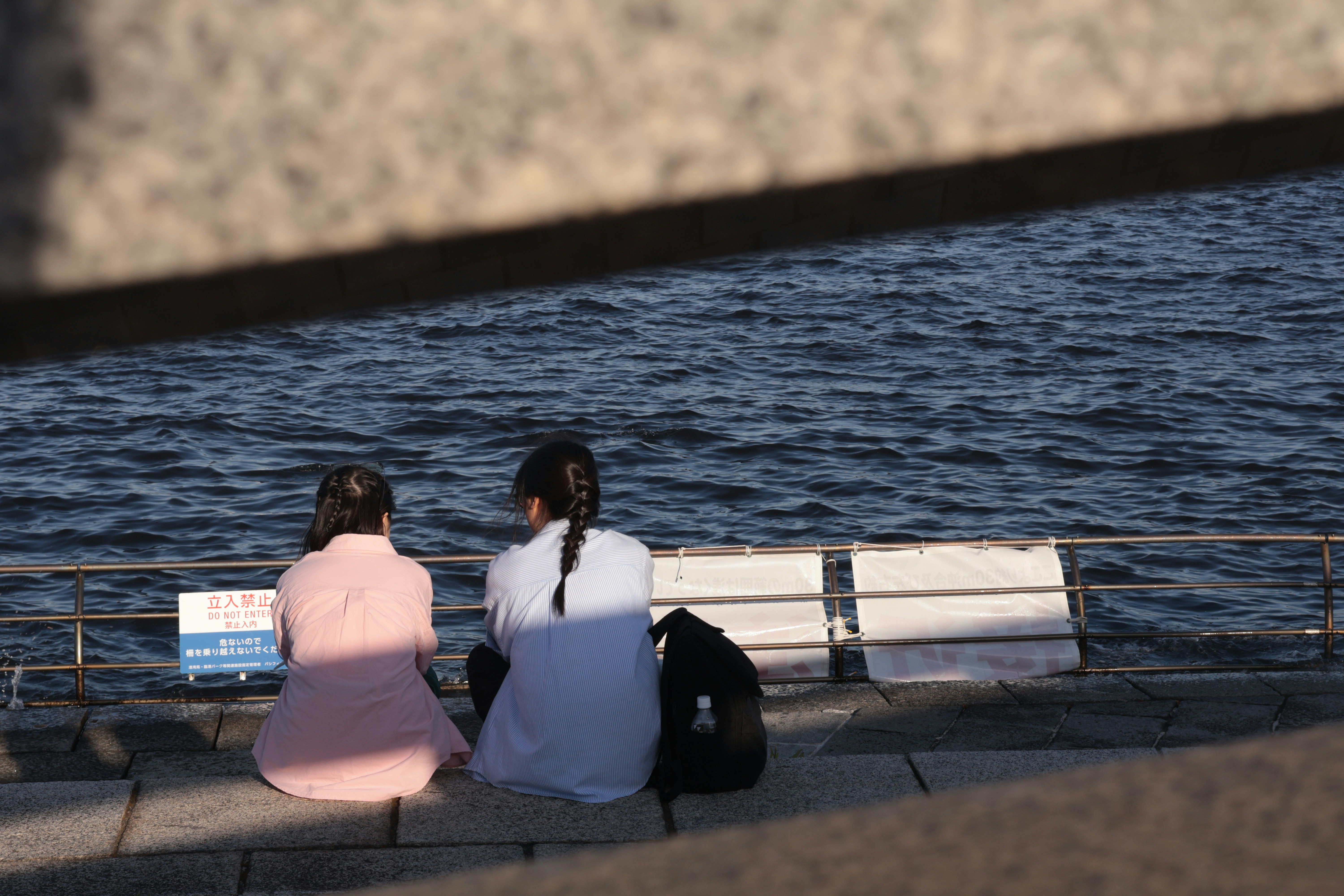 Quiet Moment by the Waterfront: Two Friends in Conversation