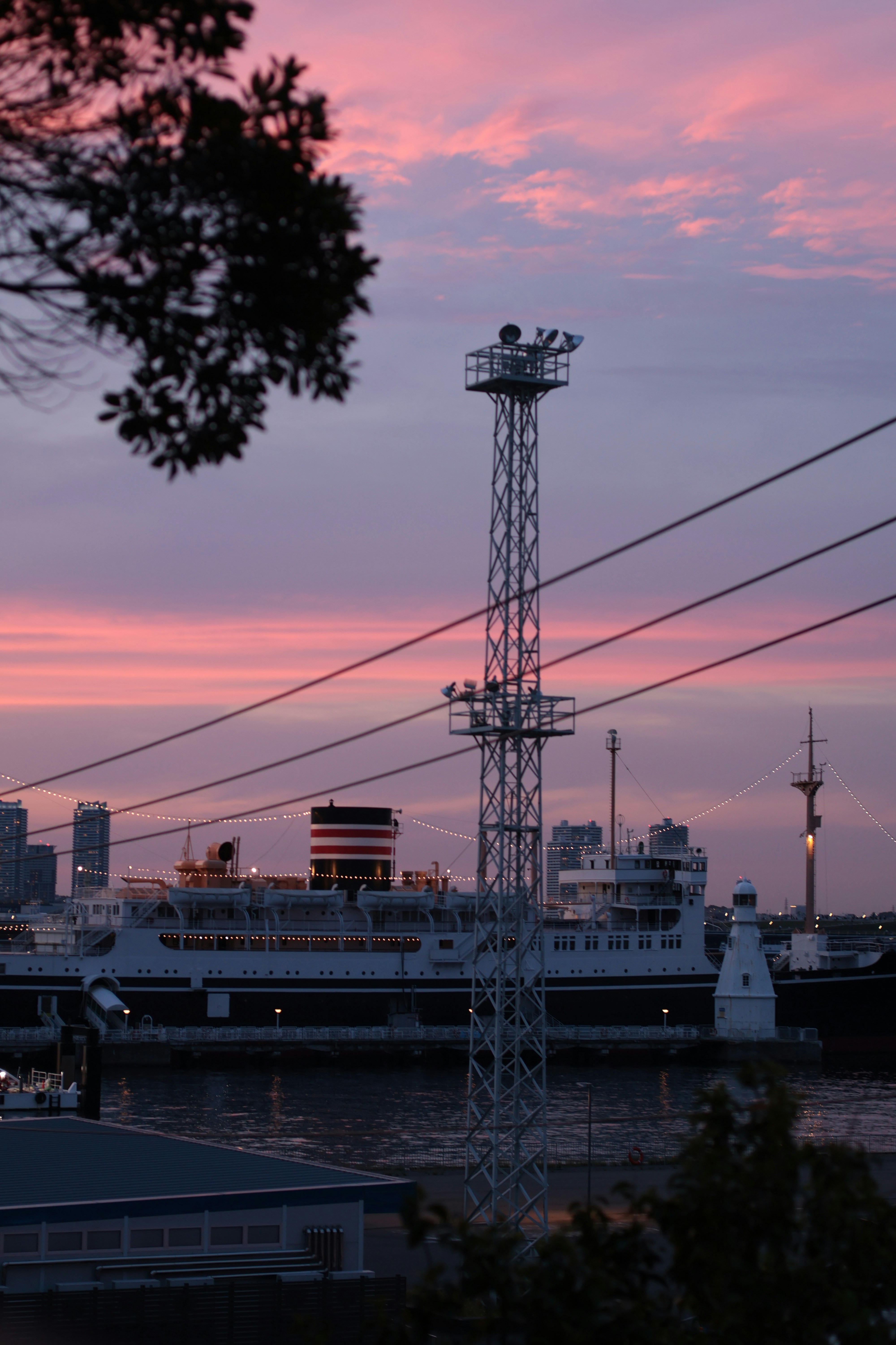 Evening Beacon Over a Waterfront Shipyard