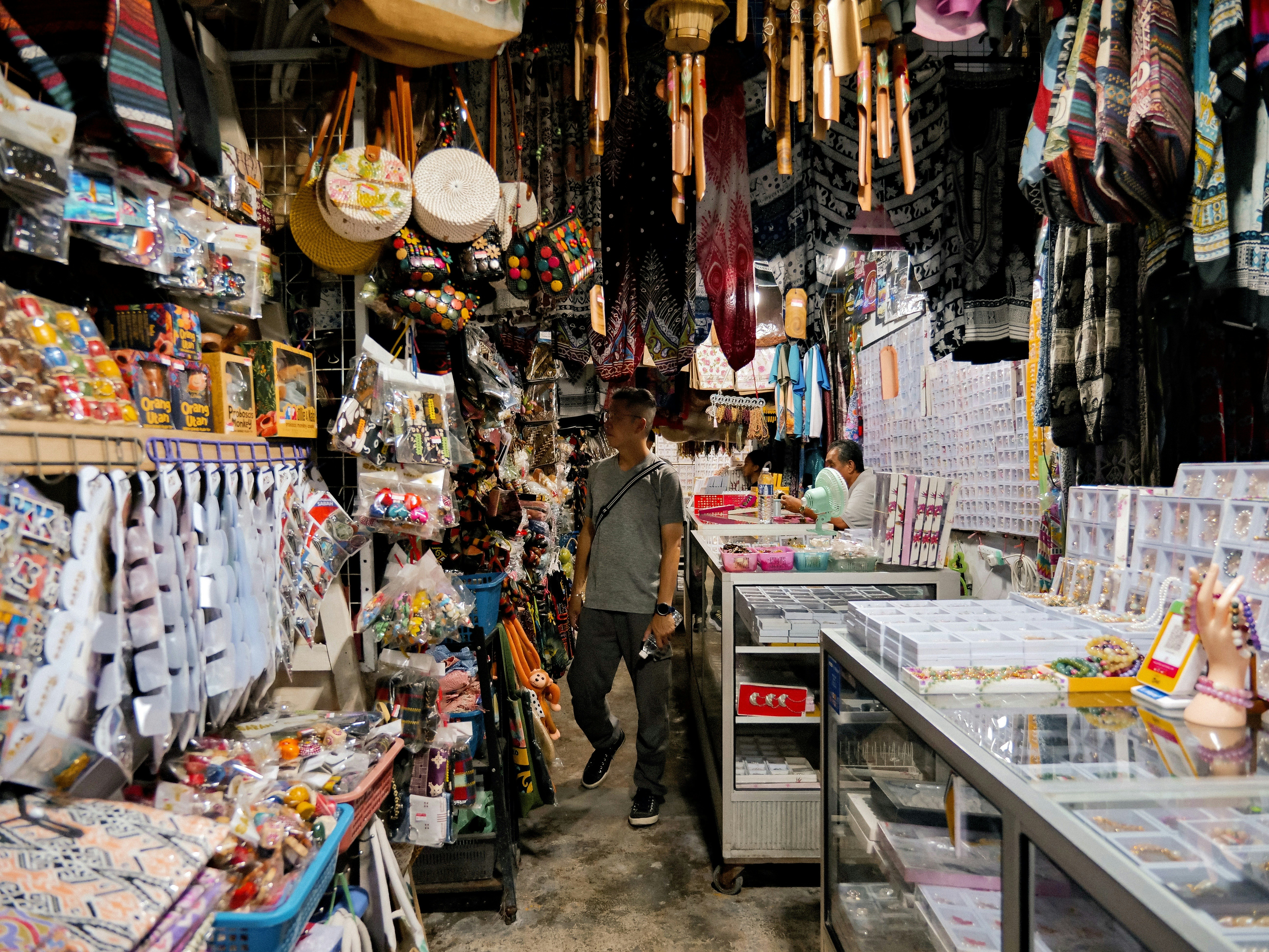 Crowded Market Aisle of Textiles and Trinkets