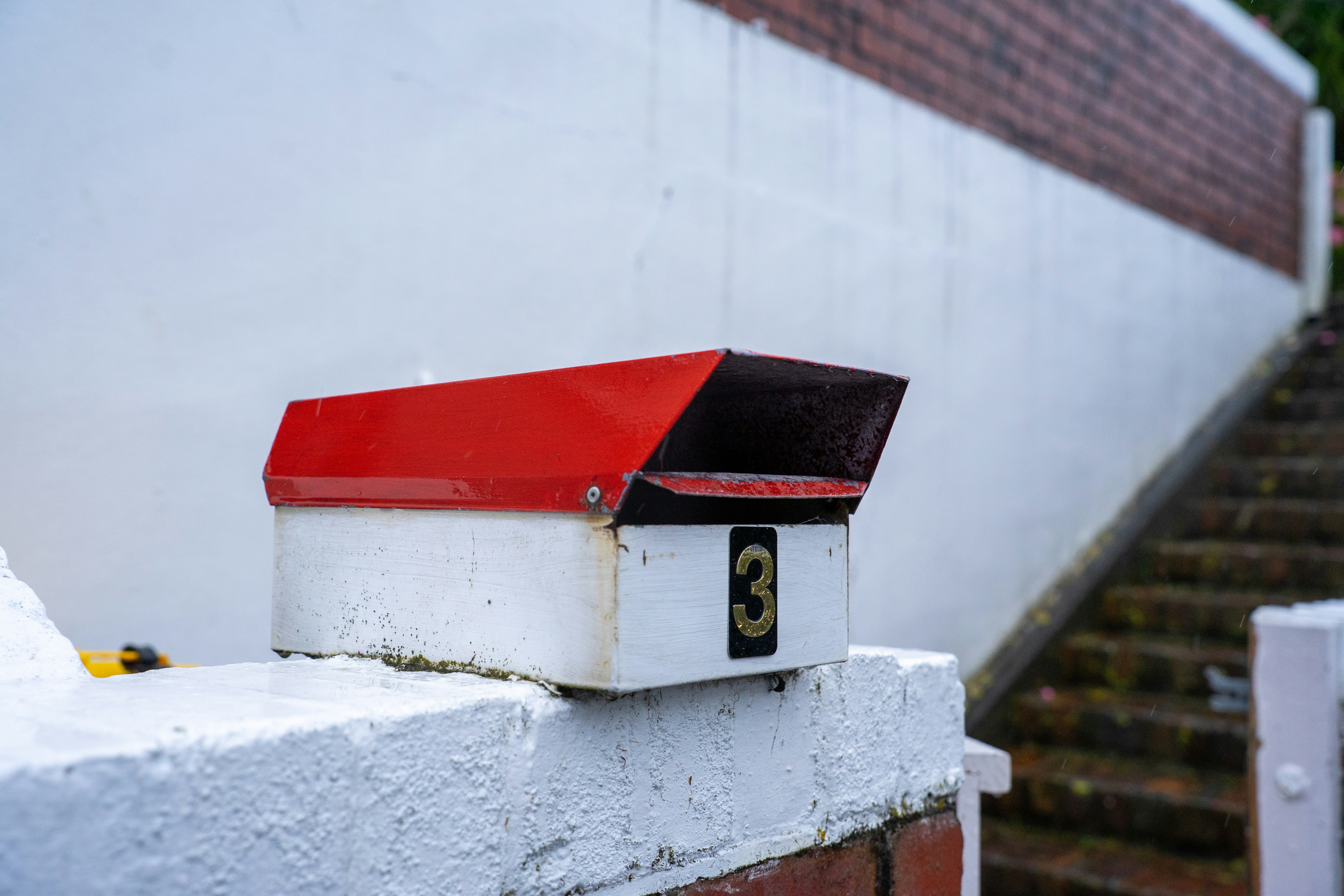 Red-Top Mailbox on a Cold Concrete Terrace