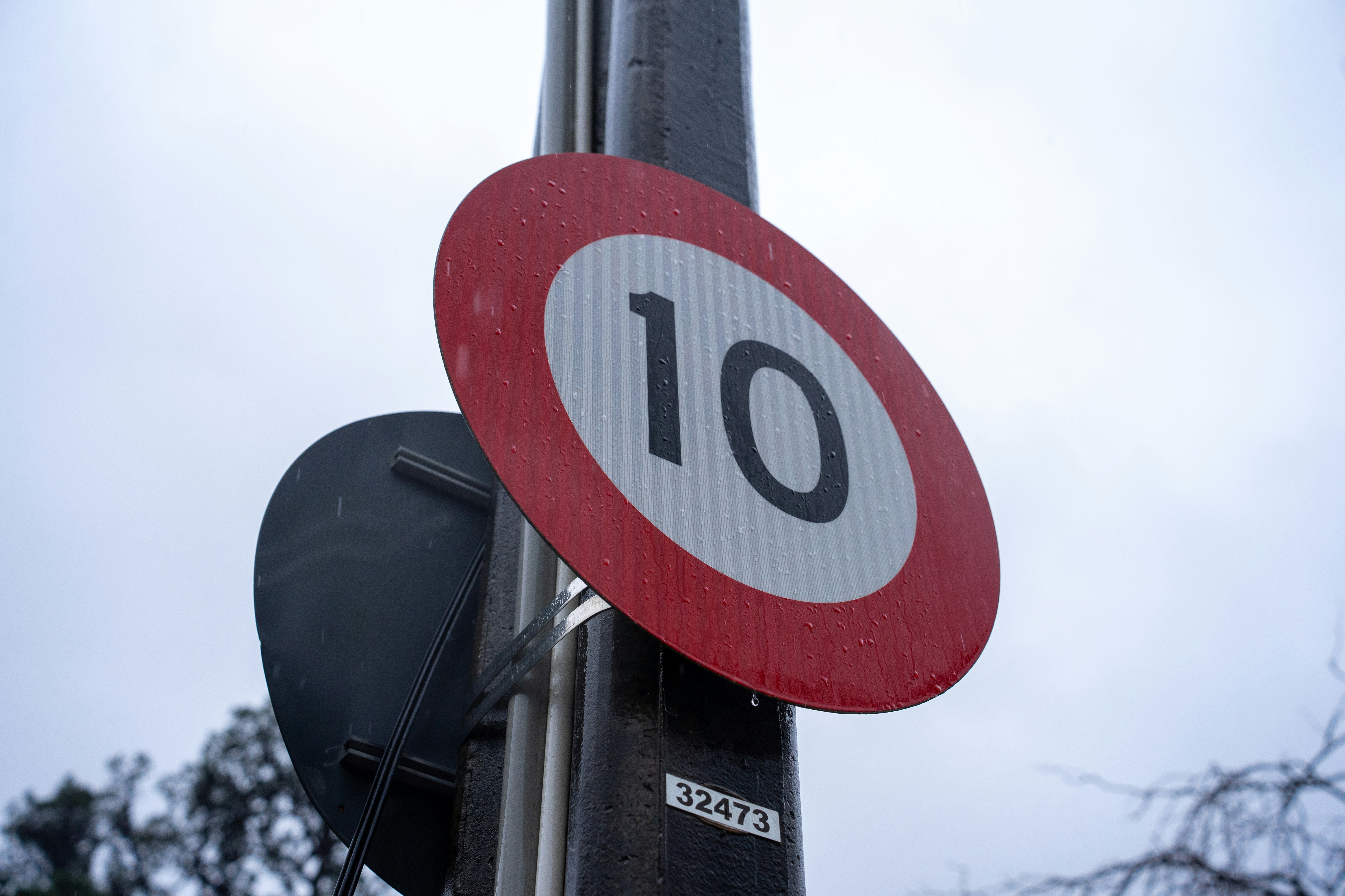 Paused Speed: A Close Look at a Circular 10 Sign on a Street Pole
