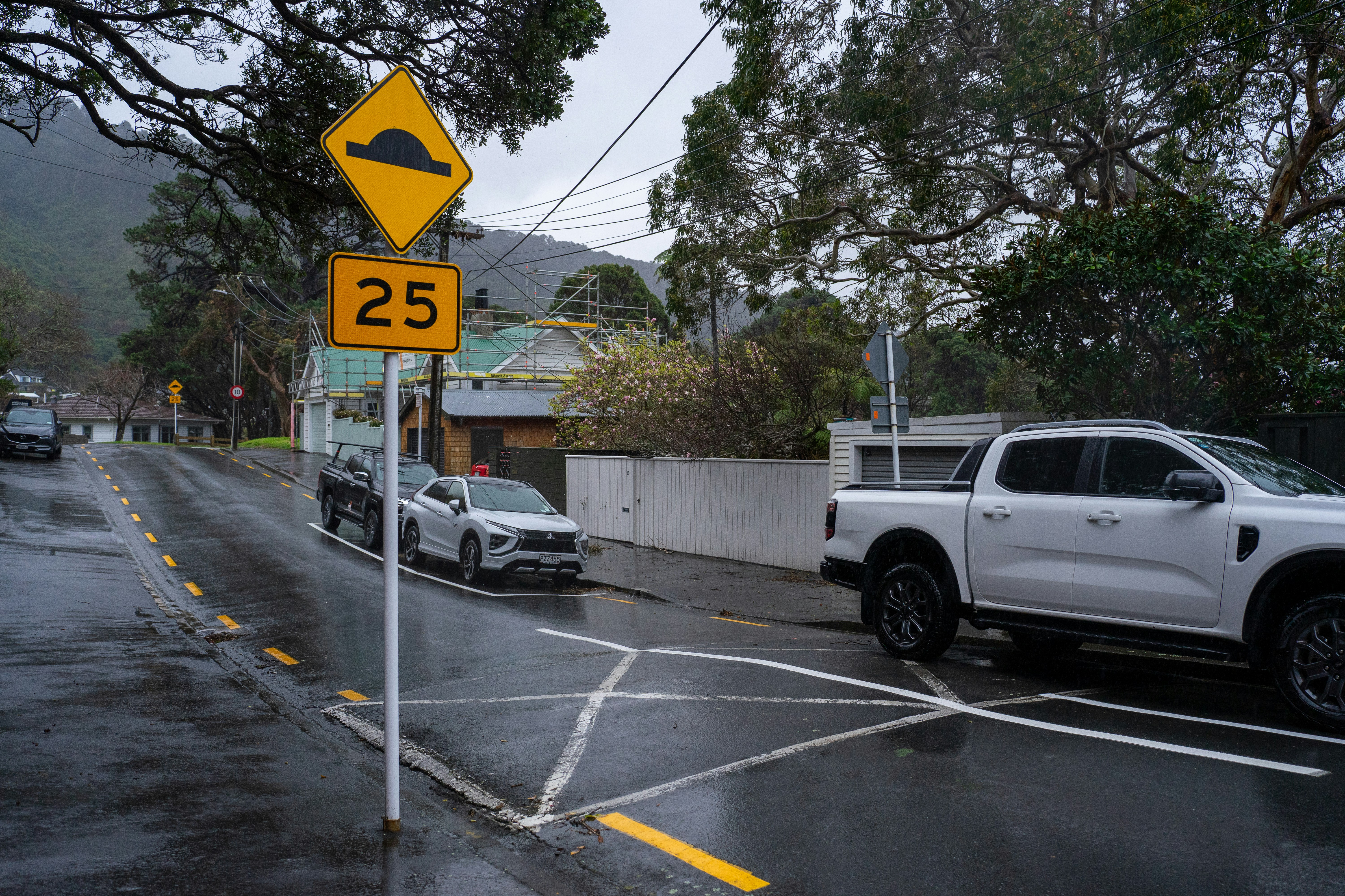 Rainy Crest: Slope Warning on a Quiet Mountain Street