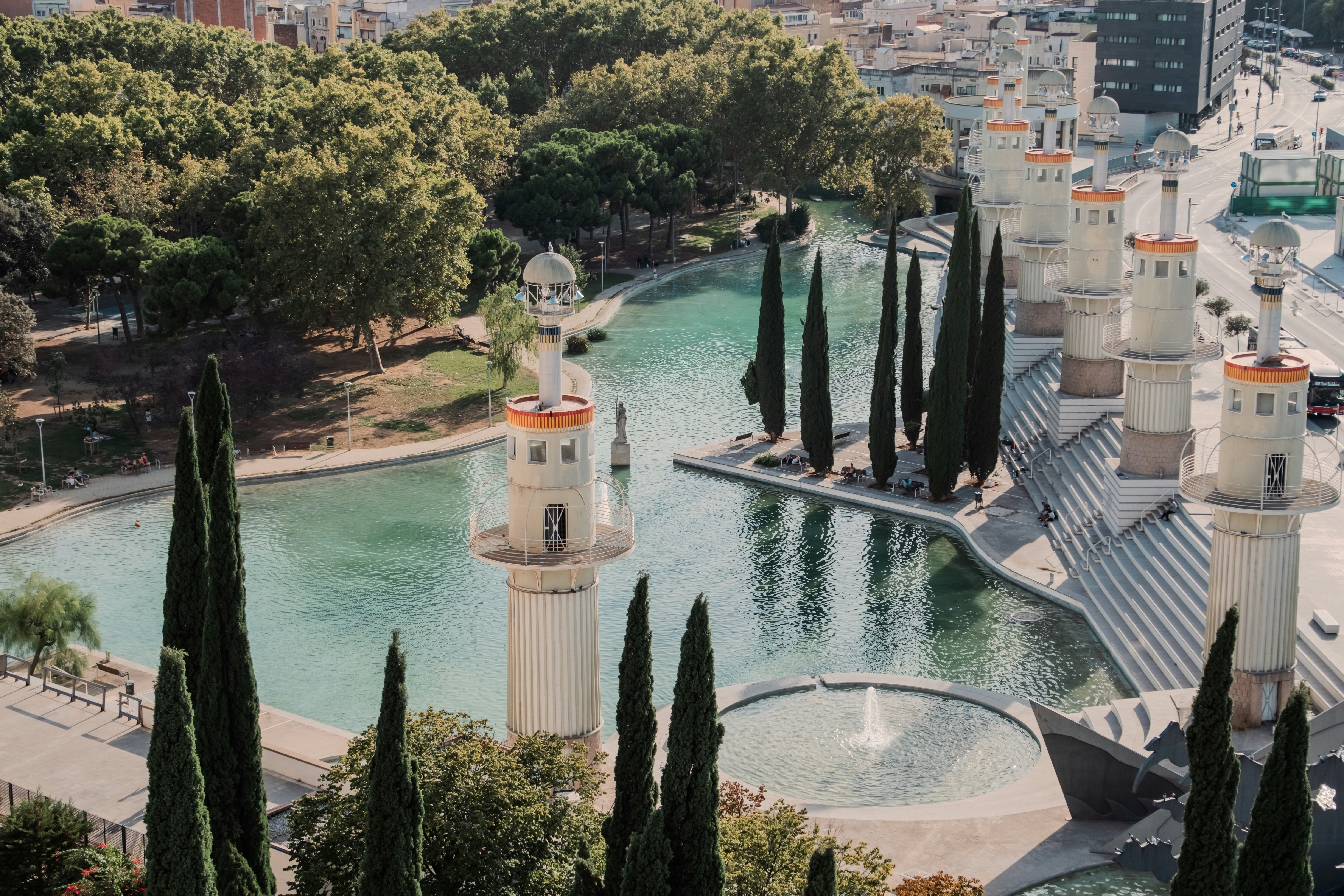 Sunlit Mediterranean Fountains: Aerial View Beneath Tall Cypress Sentinels