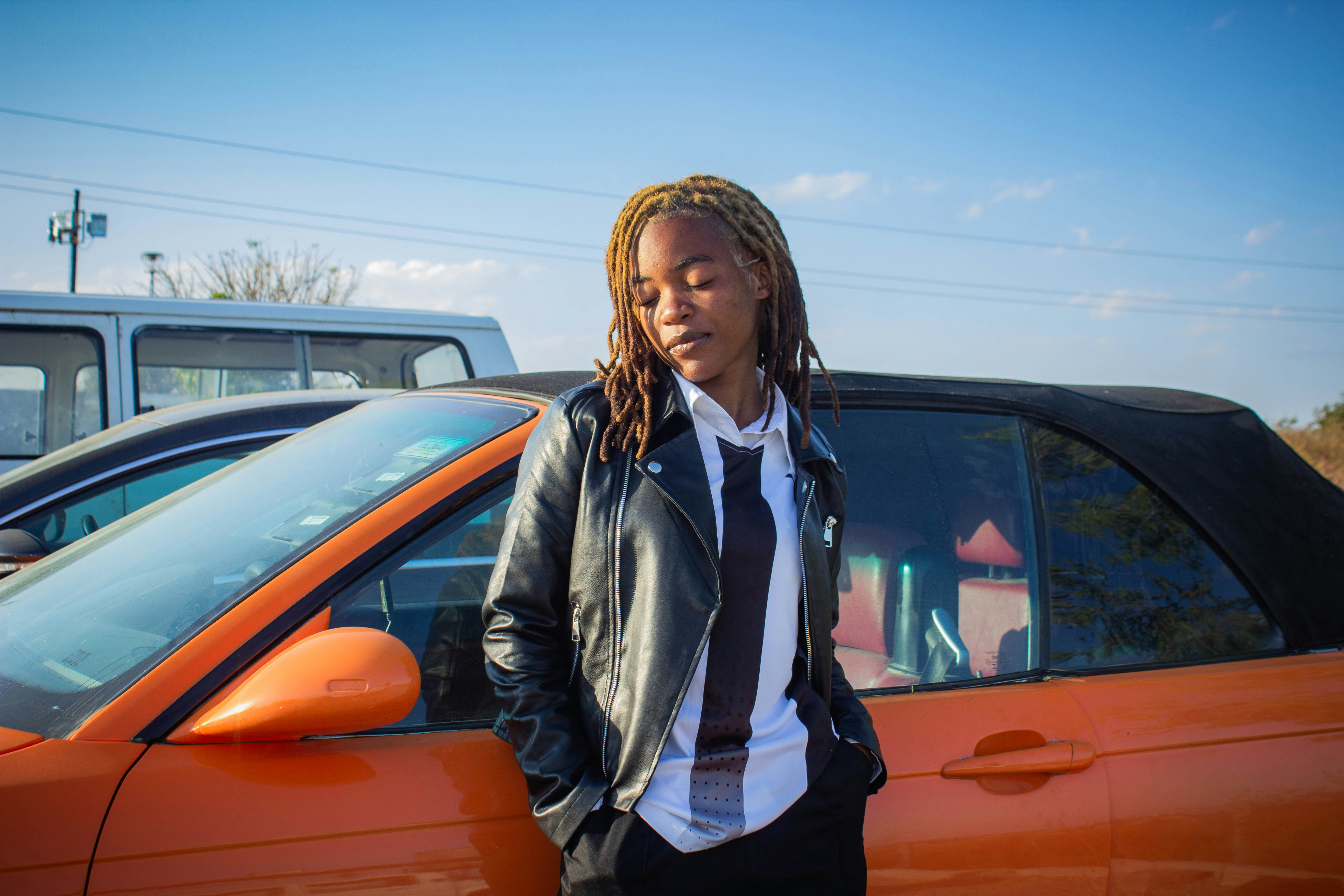 Neon-Orange Ride, Quiet Confidence: A Portrait by the Car