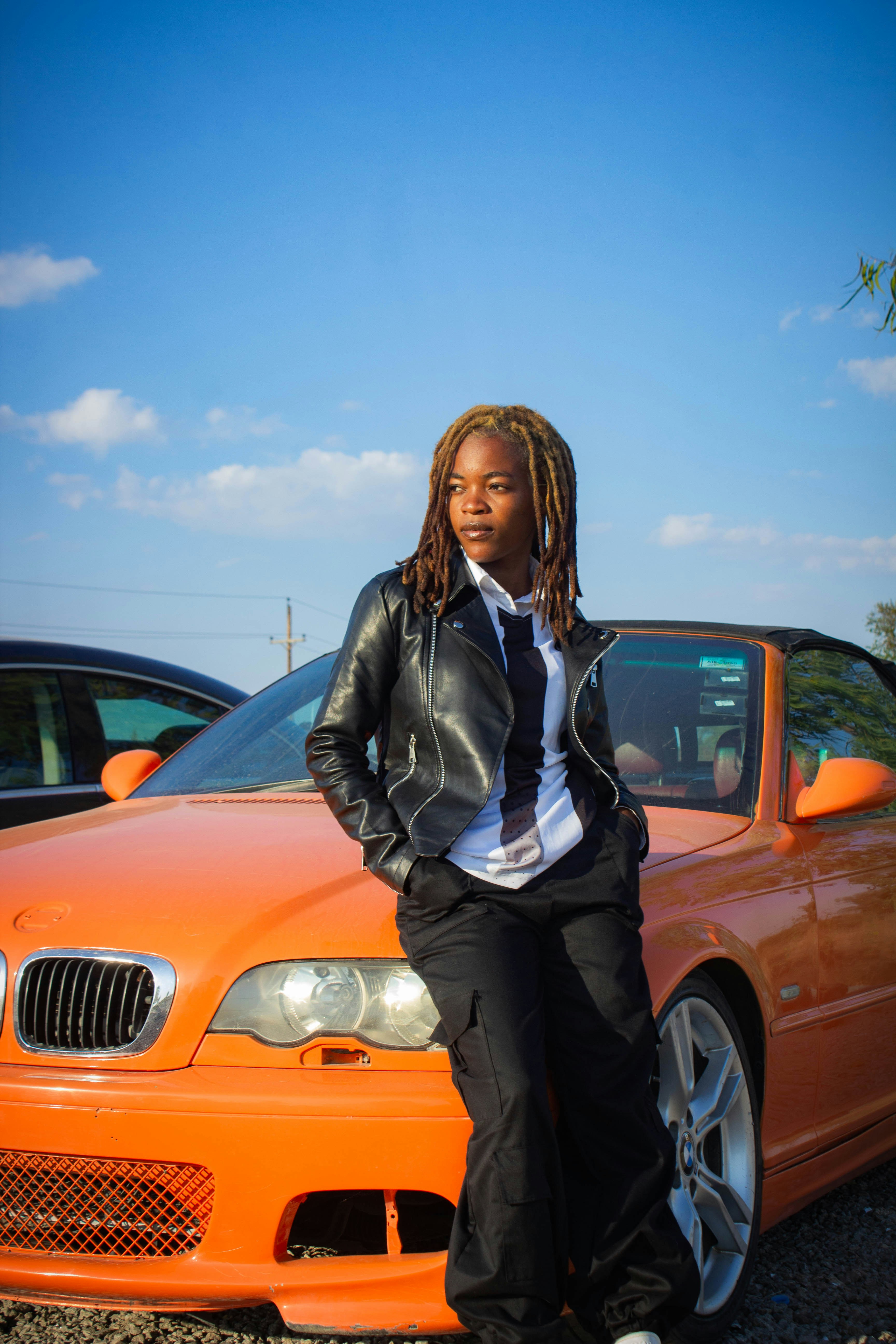 Orange Velocity: A Bold Portrait by the Car
