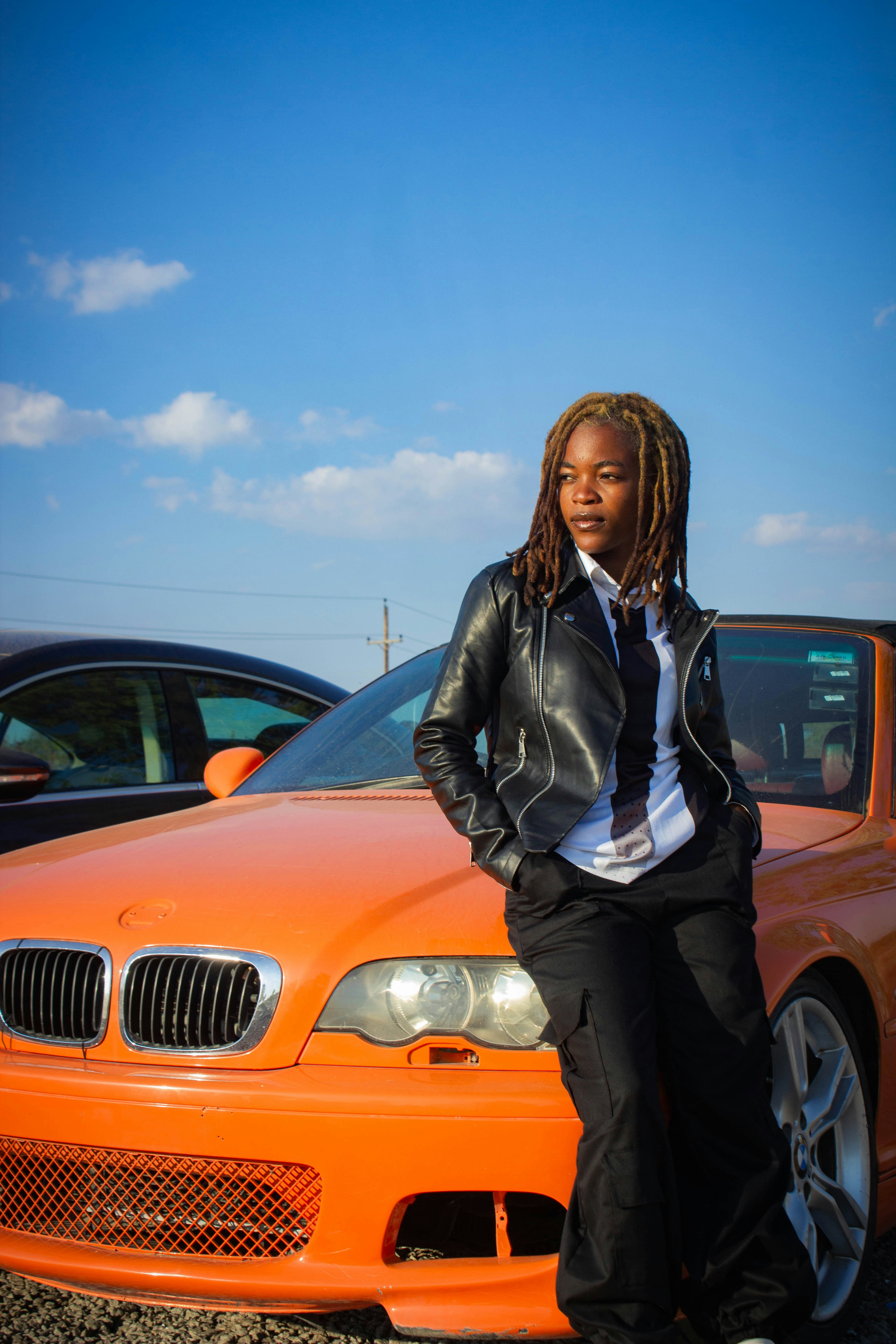 Electric Hue: A Confident Moment by the Orange Car