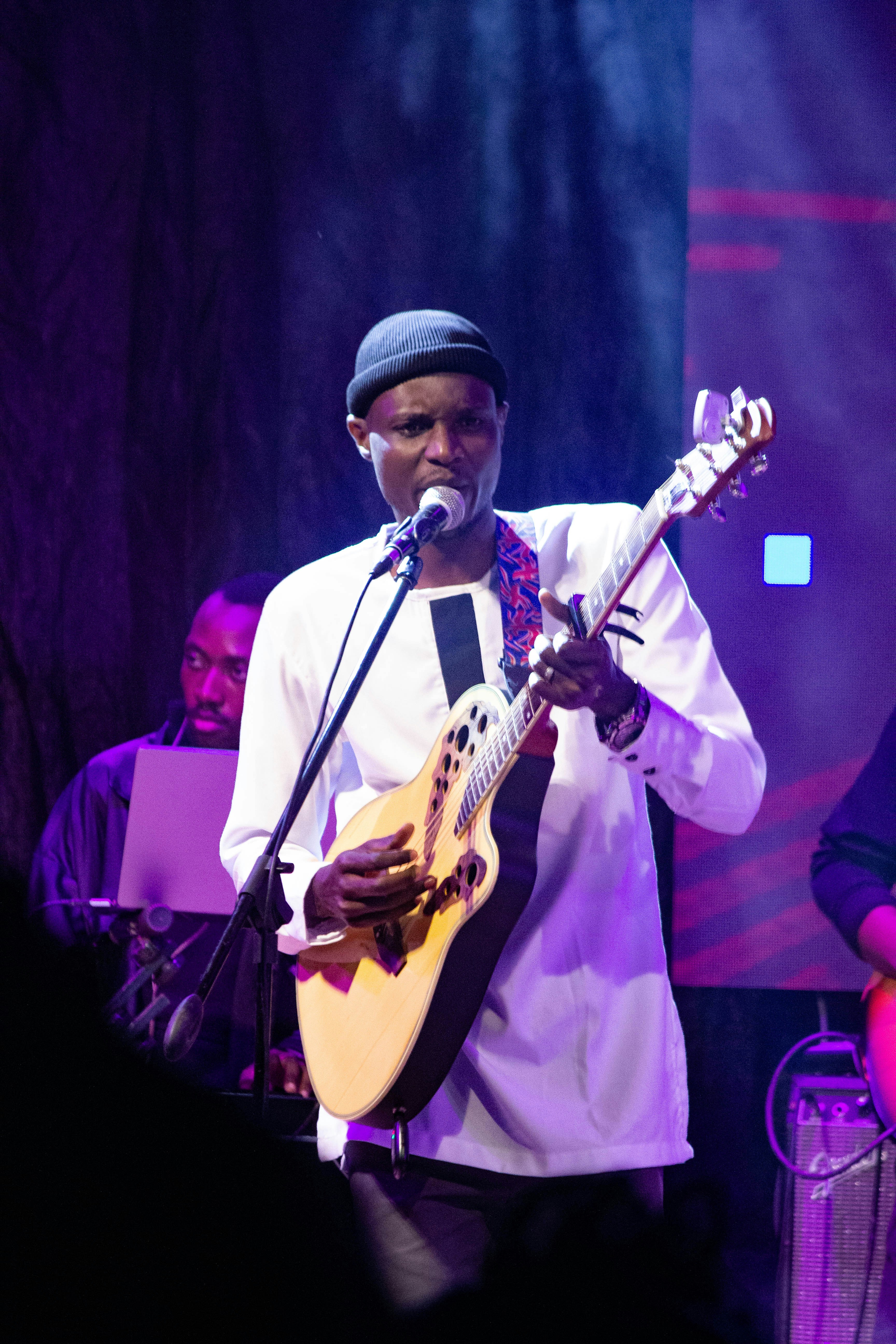 Strings and Spotlight: A Vocalist-Guitarist Under Purple Lights