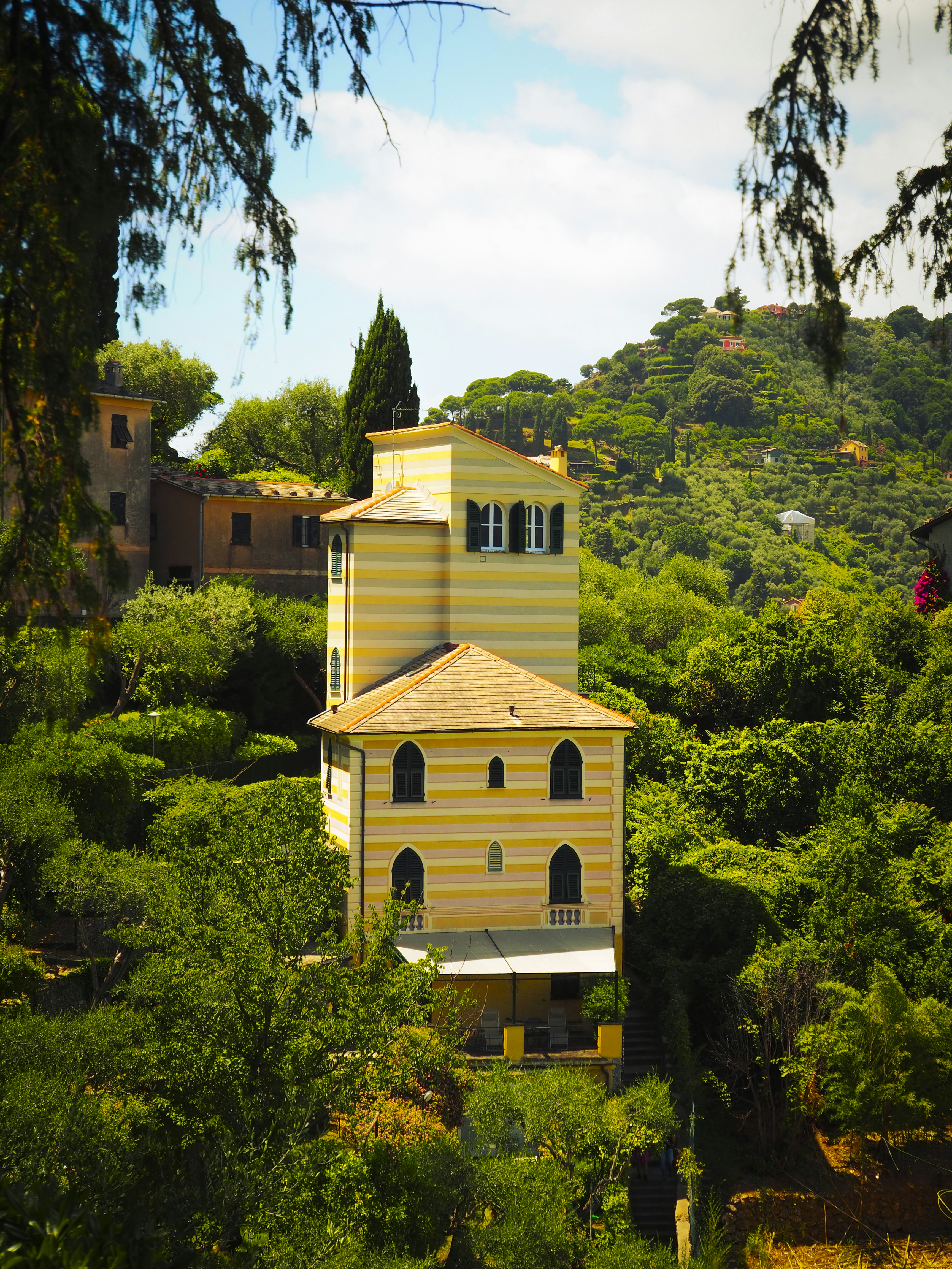 Sunlit Villas: A Striped Tower Nestled in Verdant Italian Hills