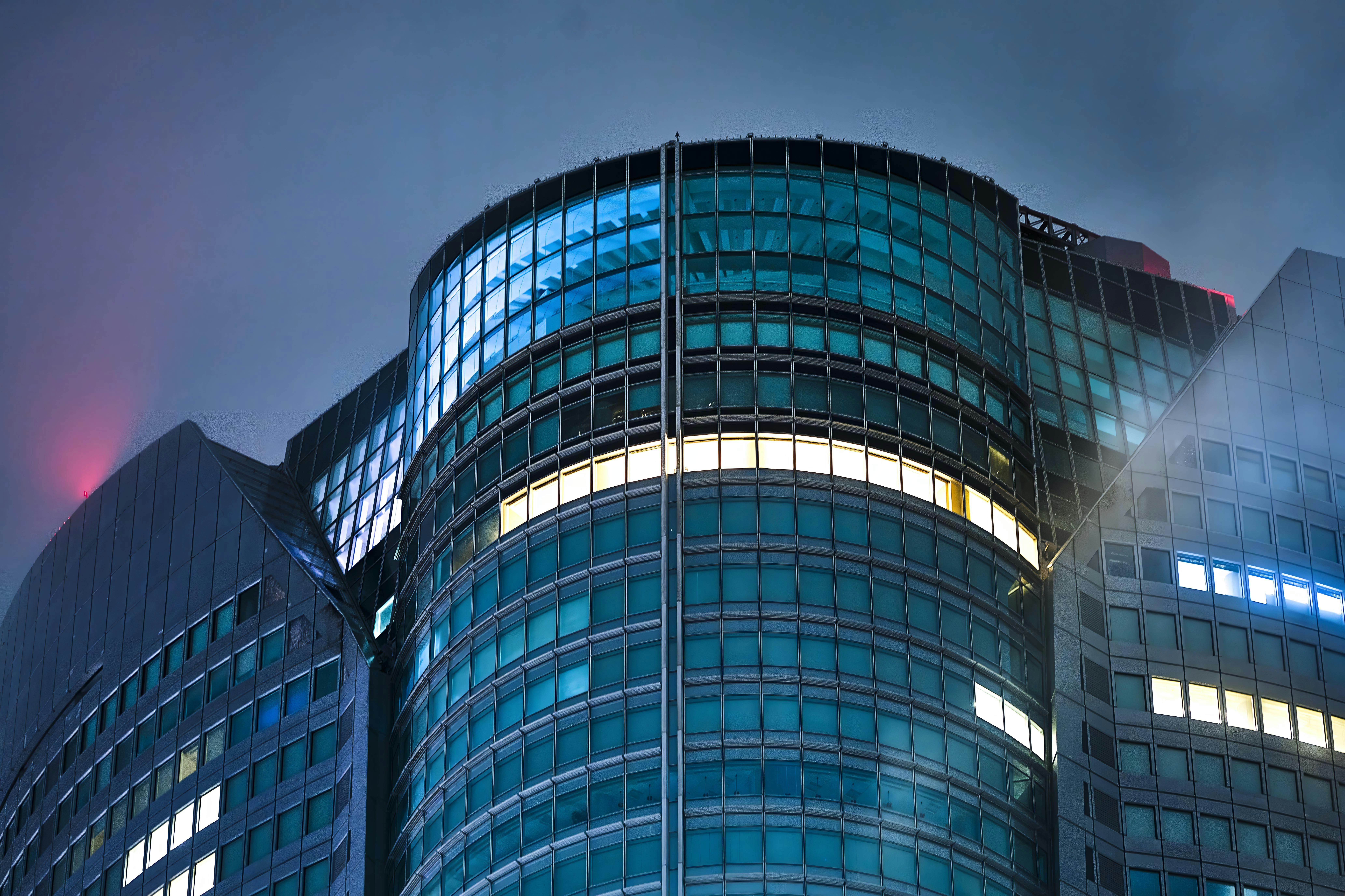 Neon-Curtained Skyward: A Curved Glass Facade Under Urban Night Lights