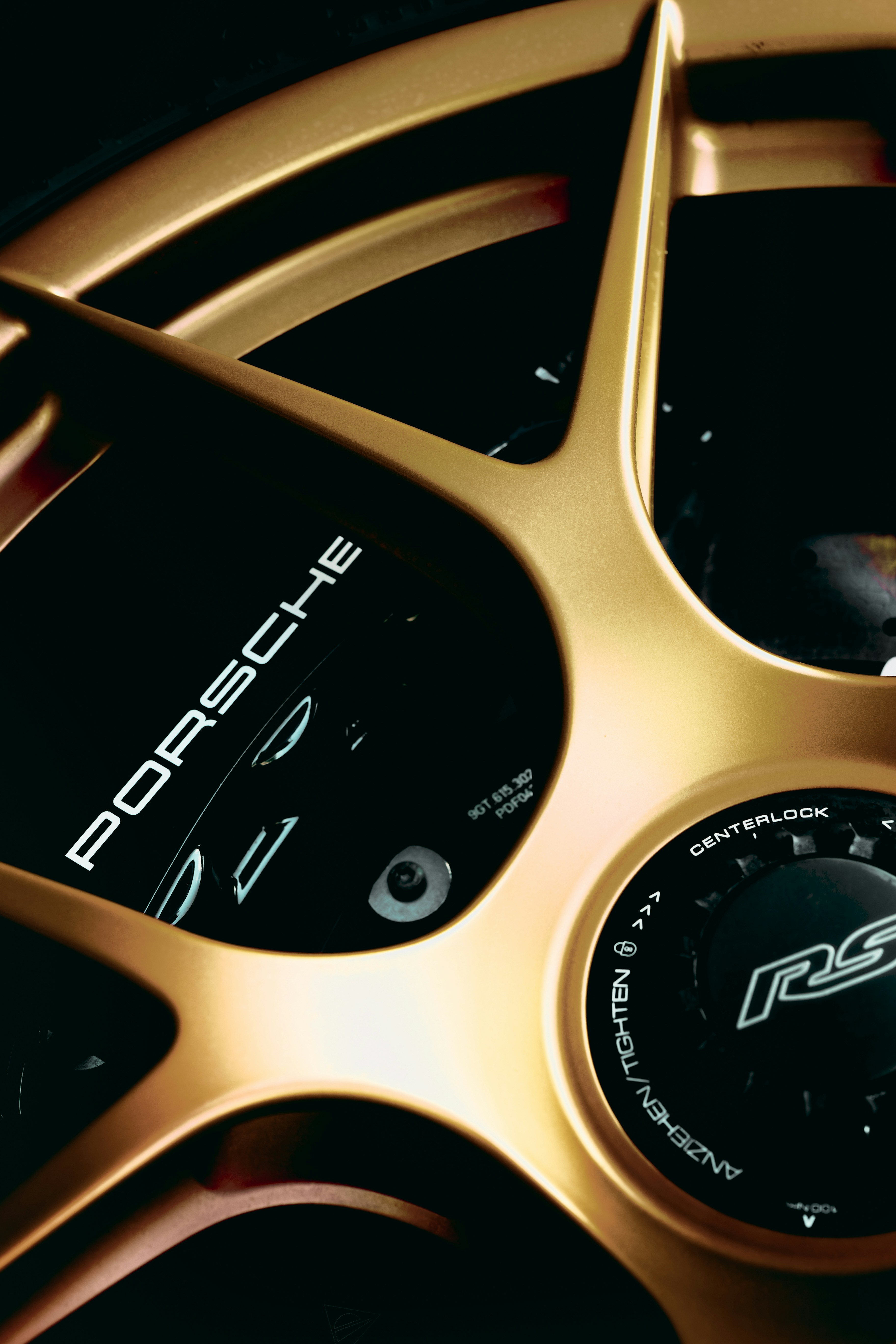 Golden spokes and Porsche silhouette: a wheel close-up in warm glow