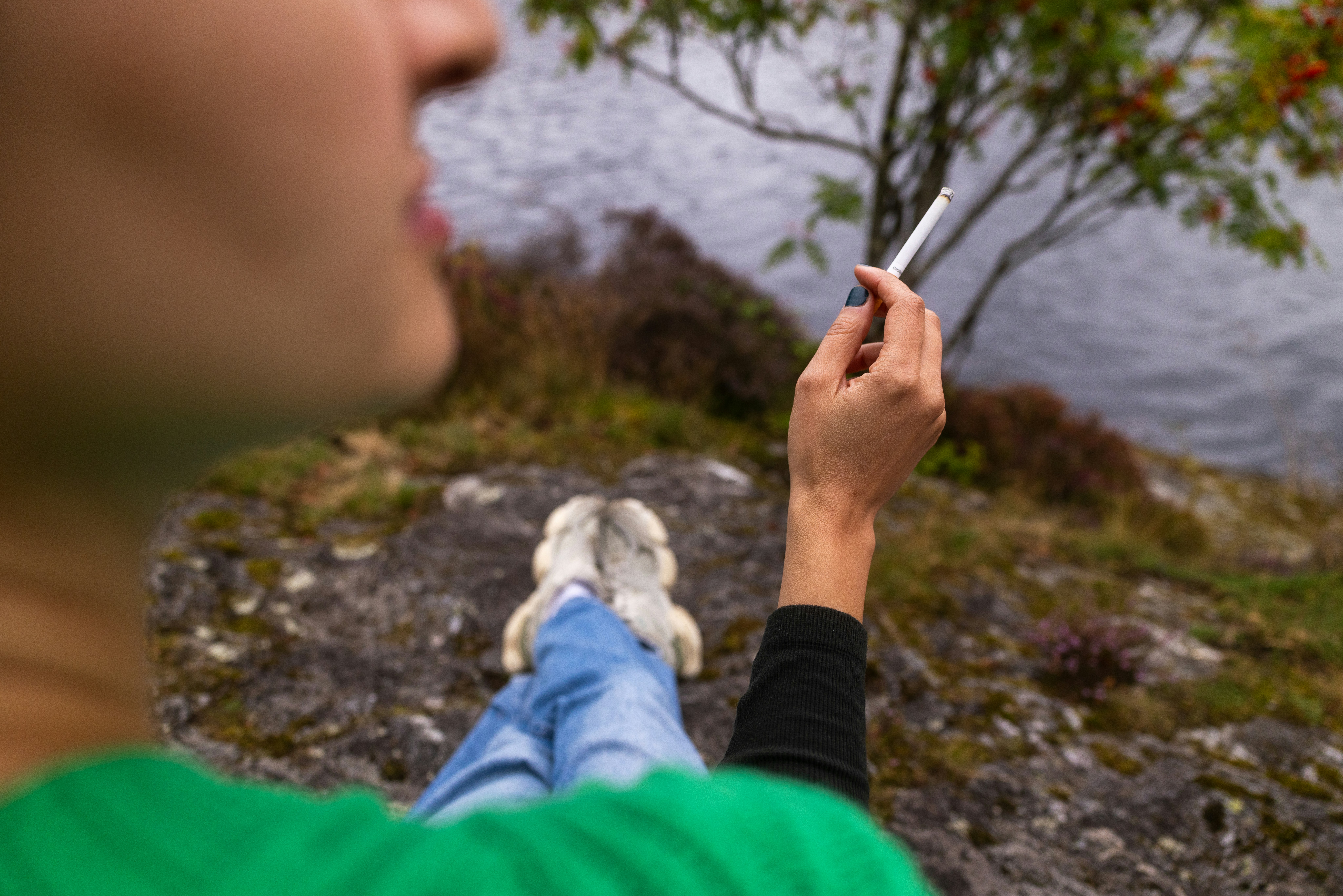 Smoke Break Over a Cliffside: A Quiet Moment by the Water