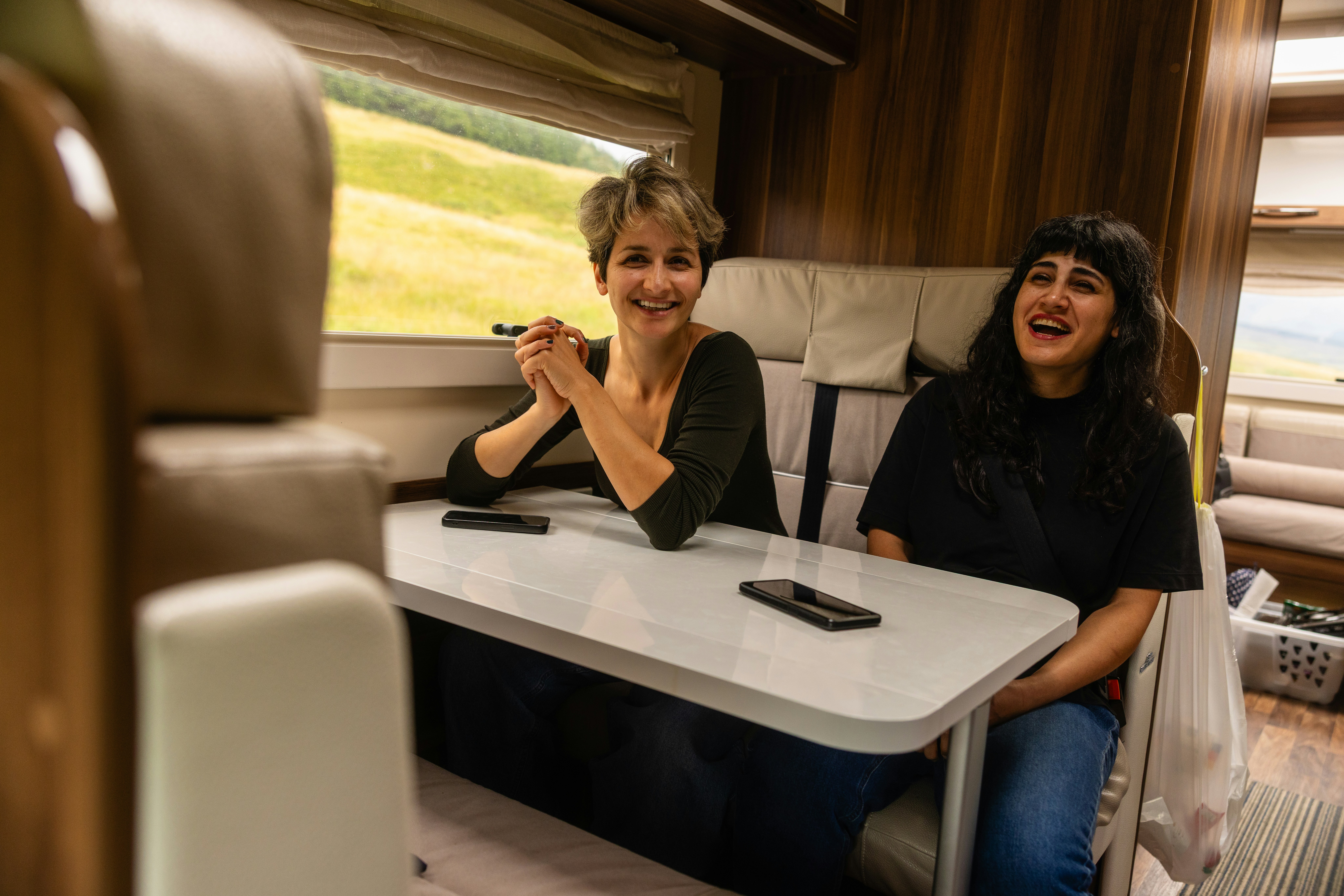 Laughing at the Table: Two Friends Inside a Train Car