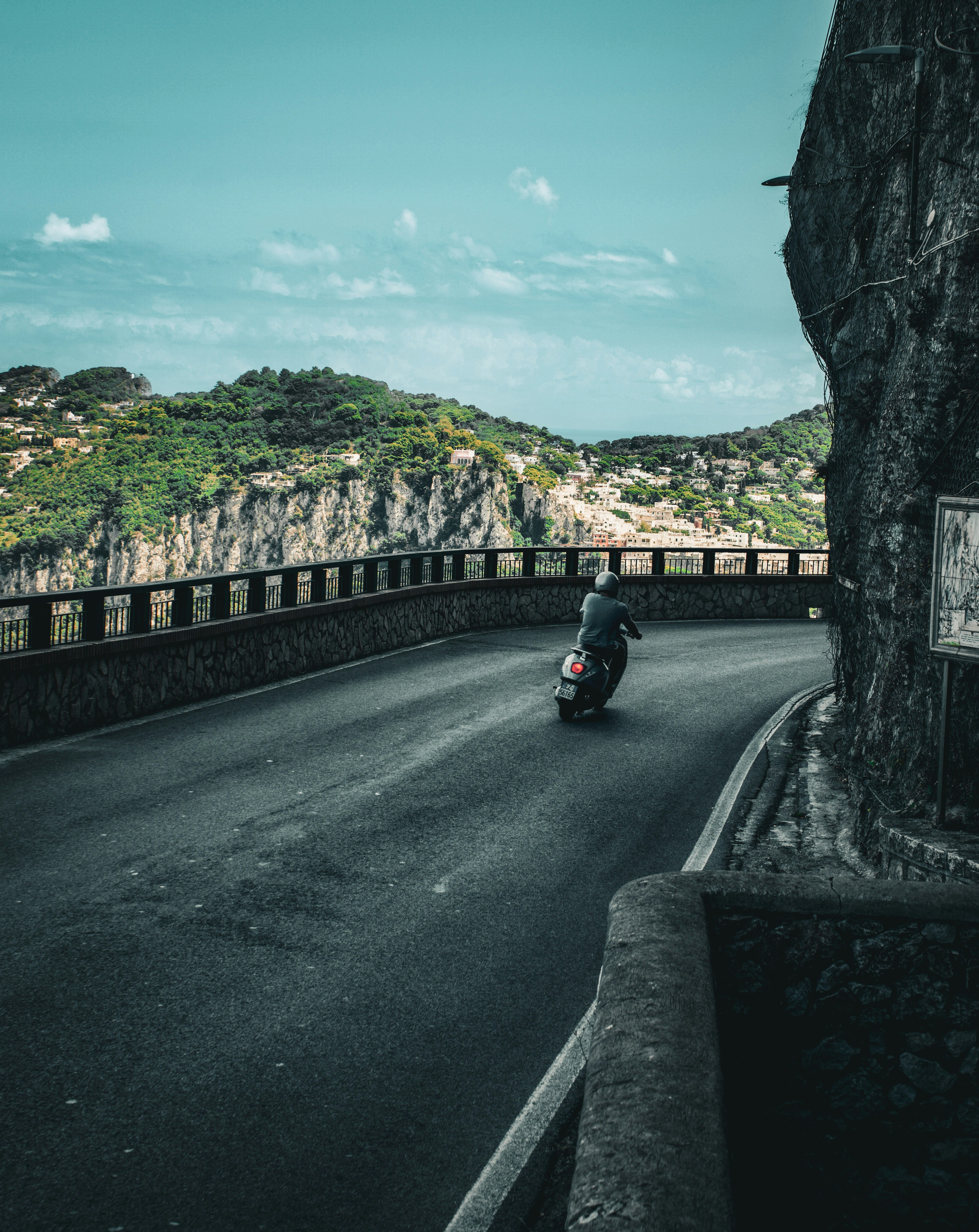 Winding Clifftop Ride: A Scooter Bends Toward the Sea